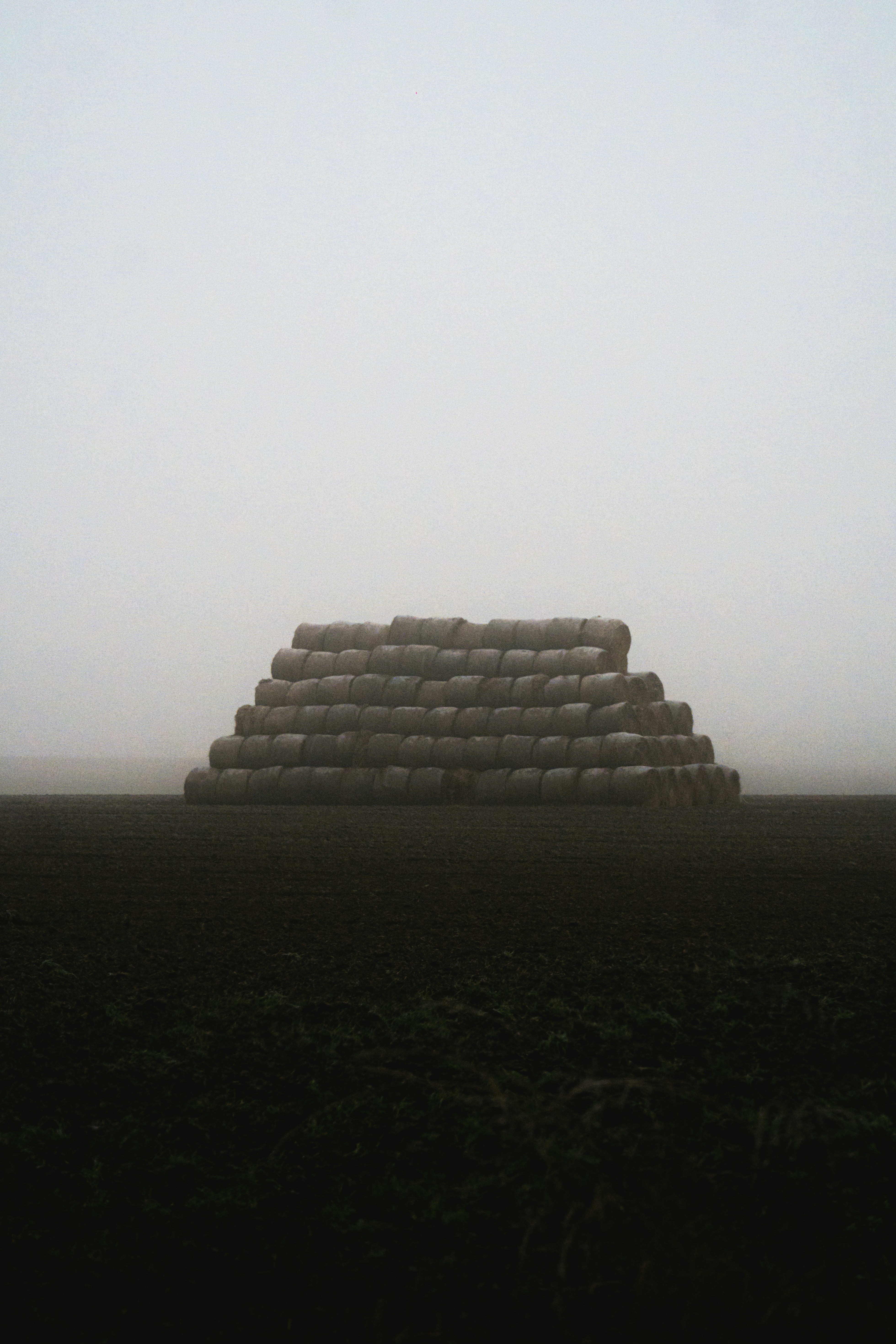 Misty Harvest: A Pyramid of Bales in the Fog