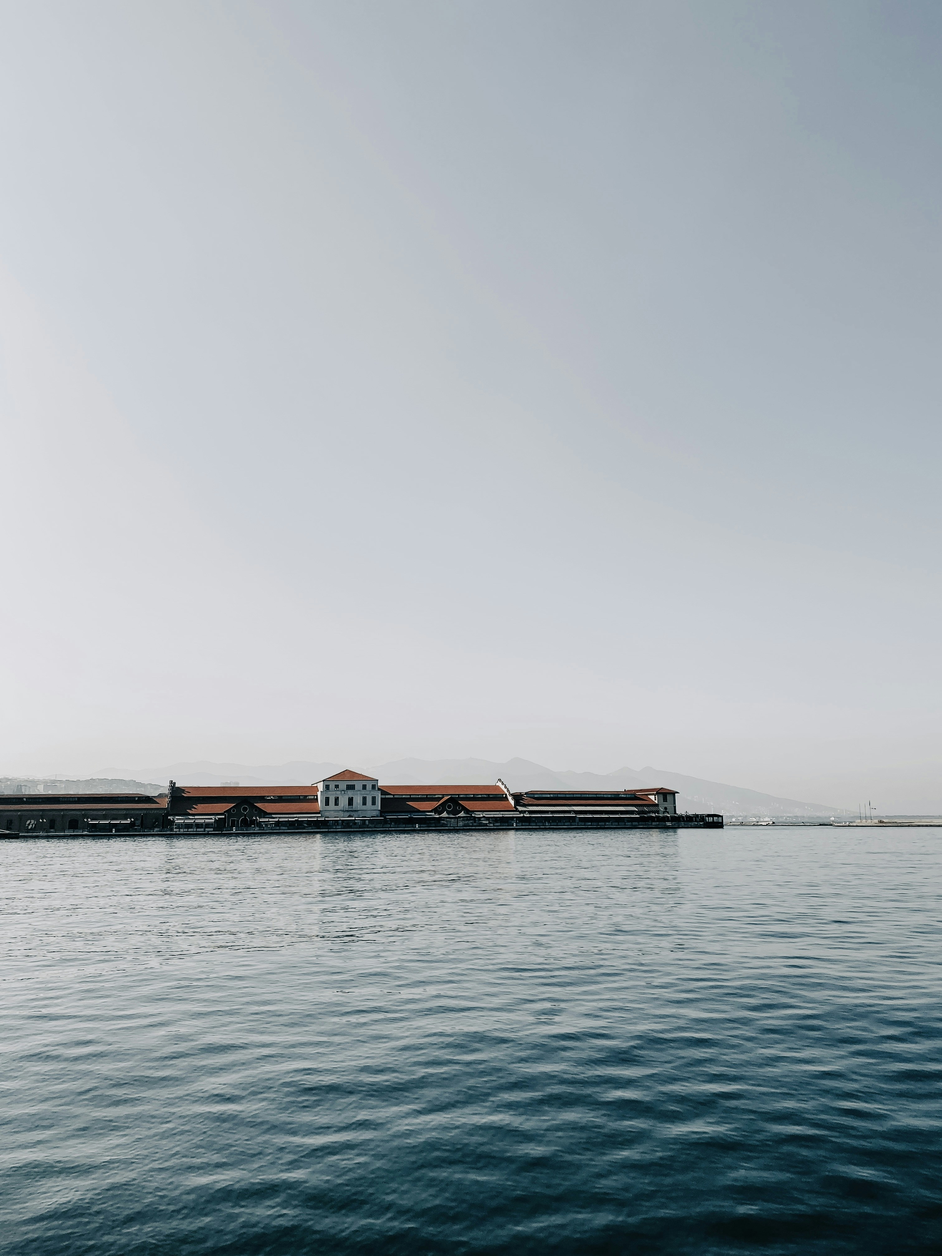 Red-Roofed Wharf Reaches Across a Glassy Sea