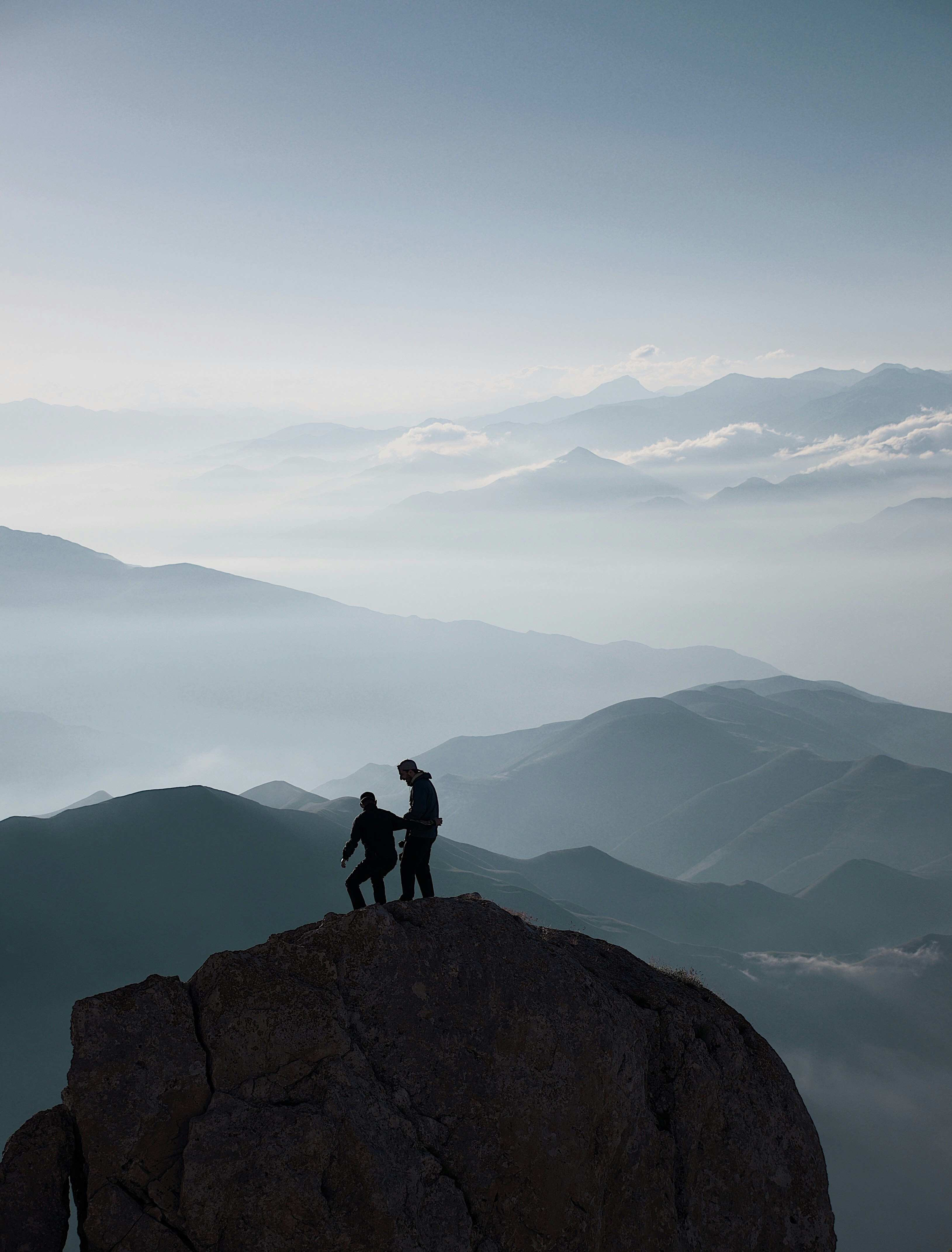 Dawn on the Crest: Two Climbers Stand at the Summit's Verge