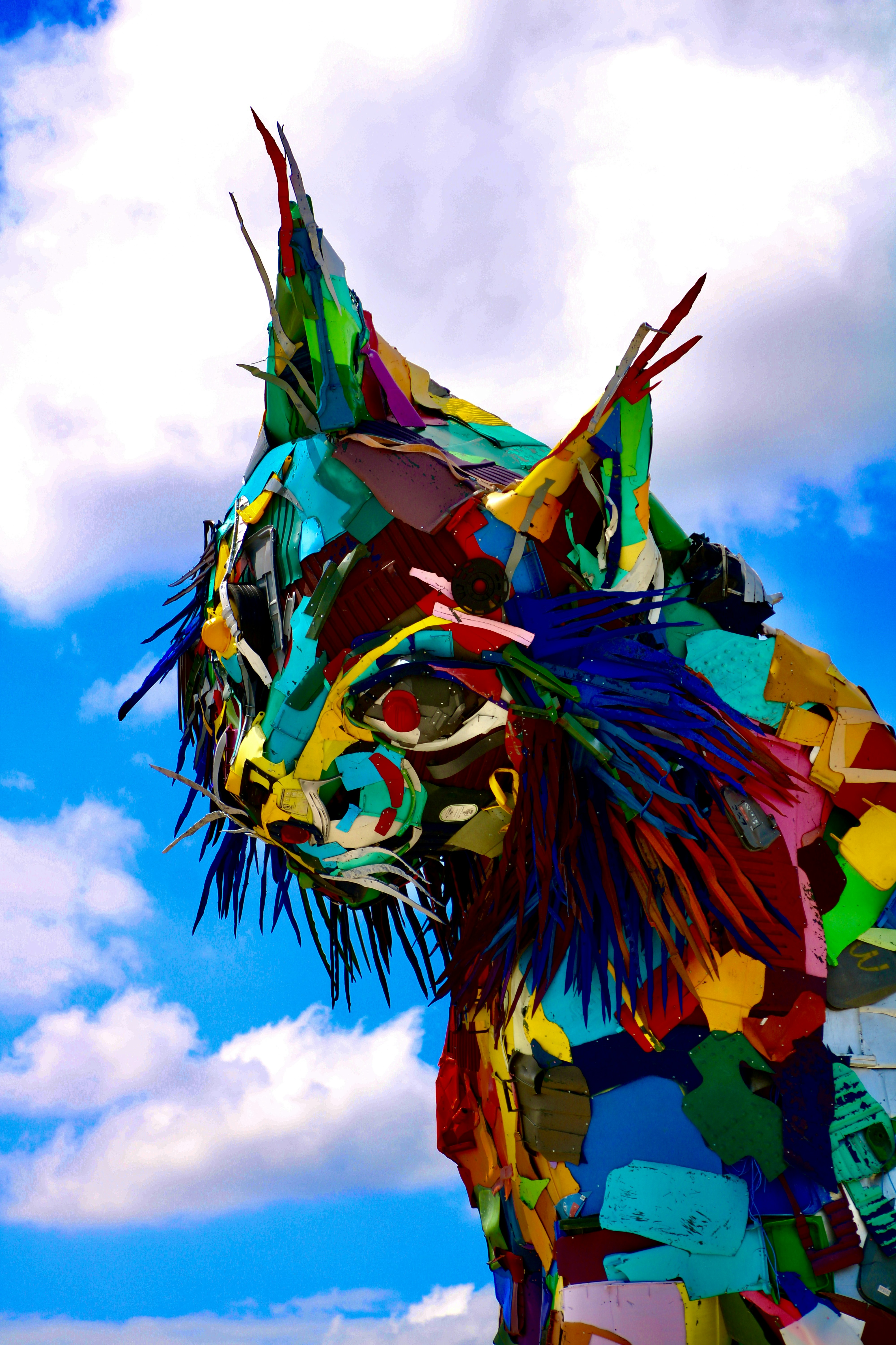 Patchwork Stallion: a colorful dragon-headed horse sculpture against a bright sky