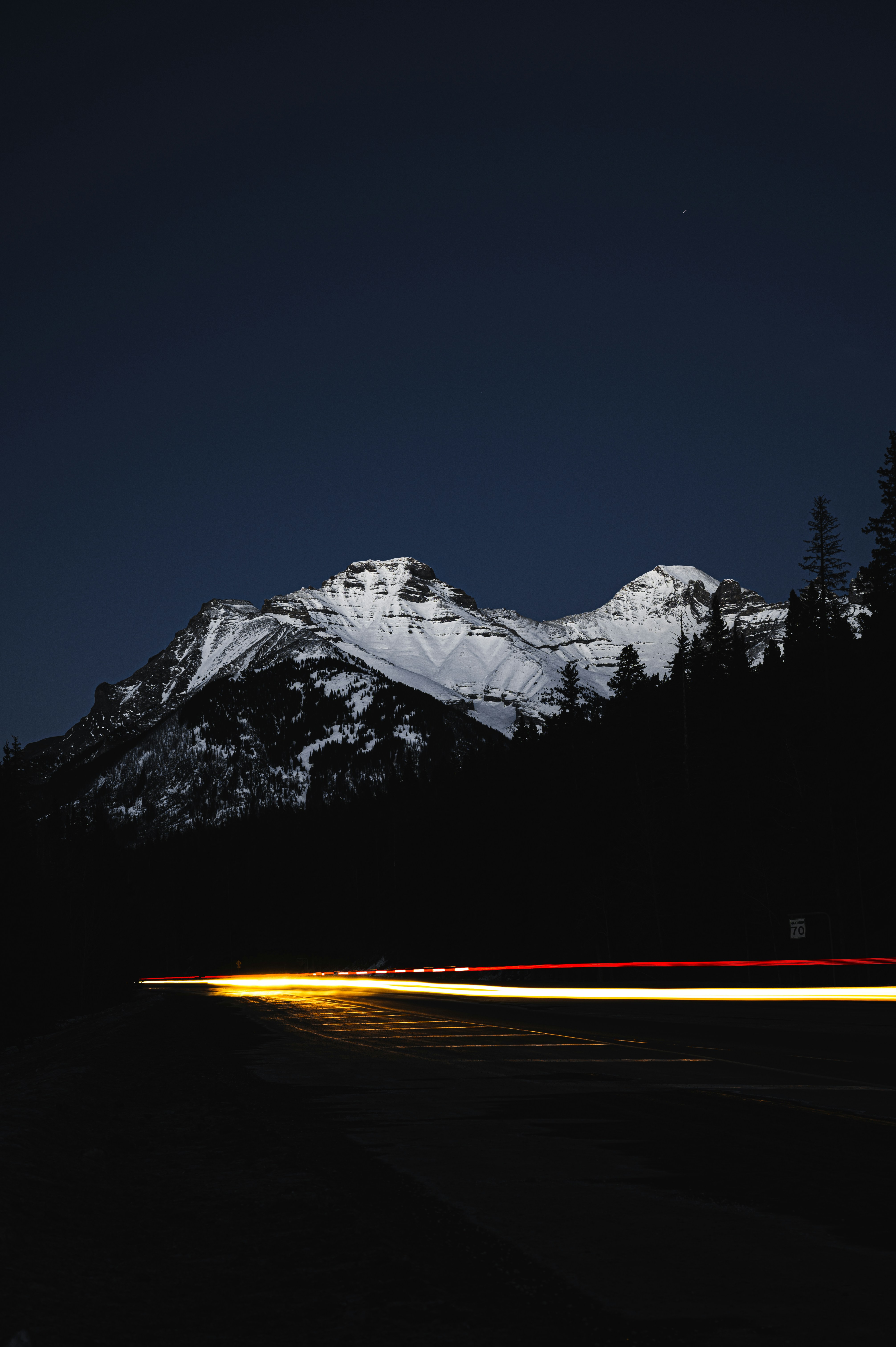 Snowbound Peak Under a Velvet Night with Moving Lights