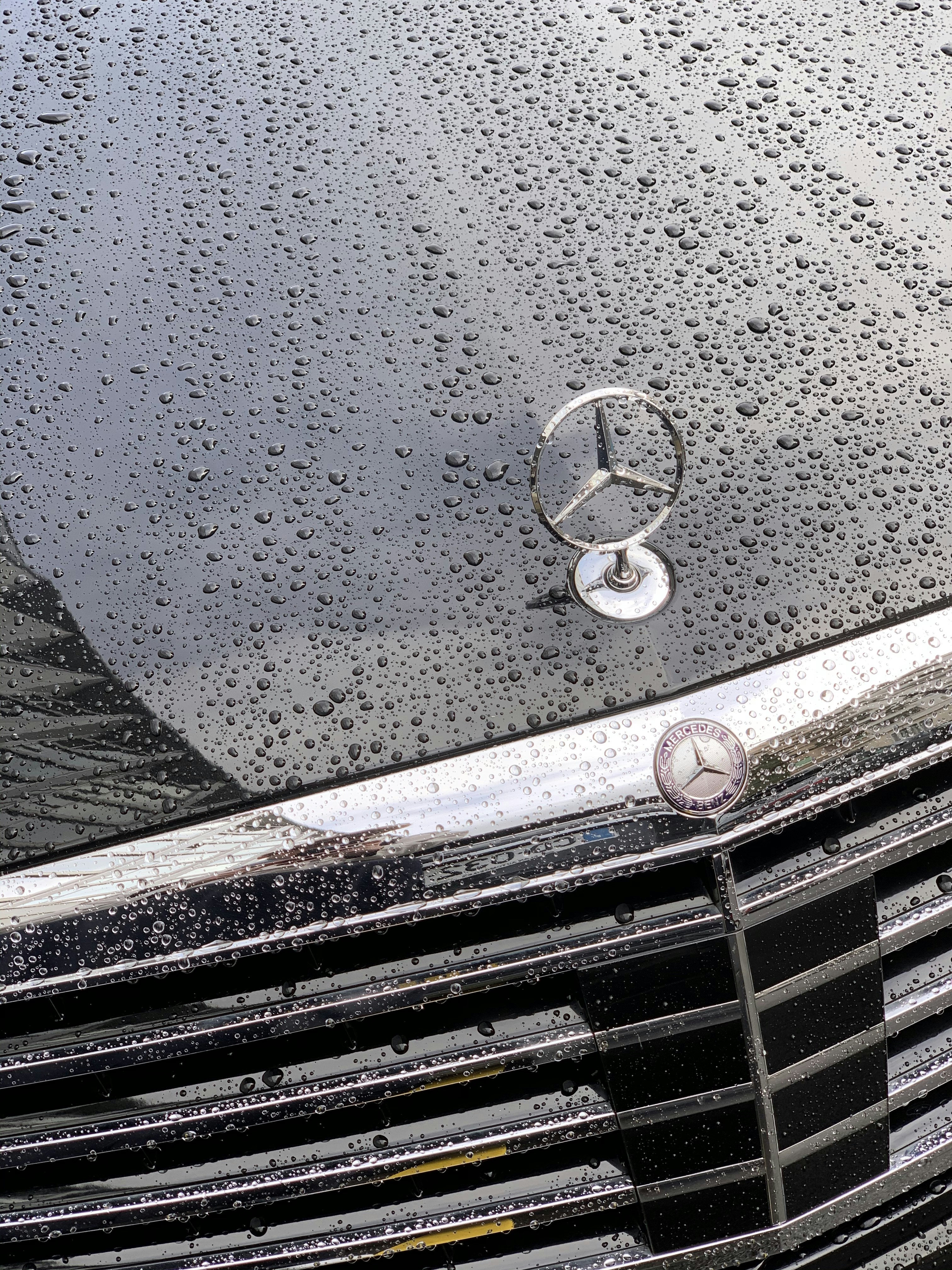 Rain-kissed Chrome: The Mercedes-Benz Emblem on a Rain-Soaked Hood