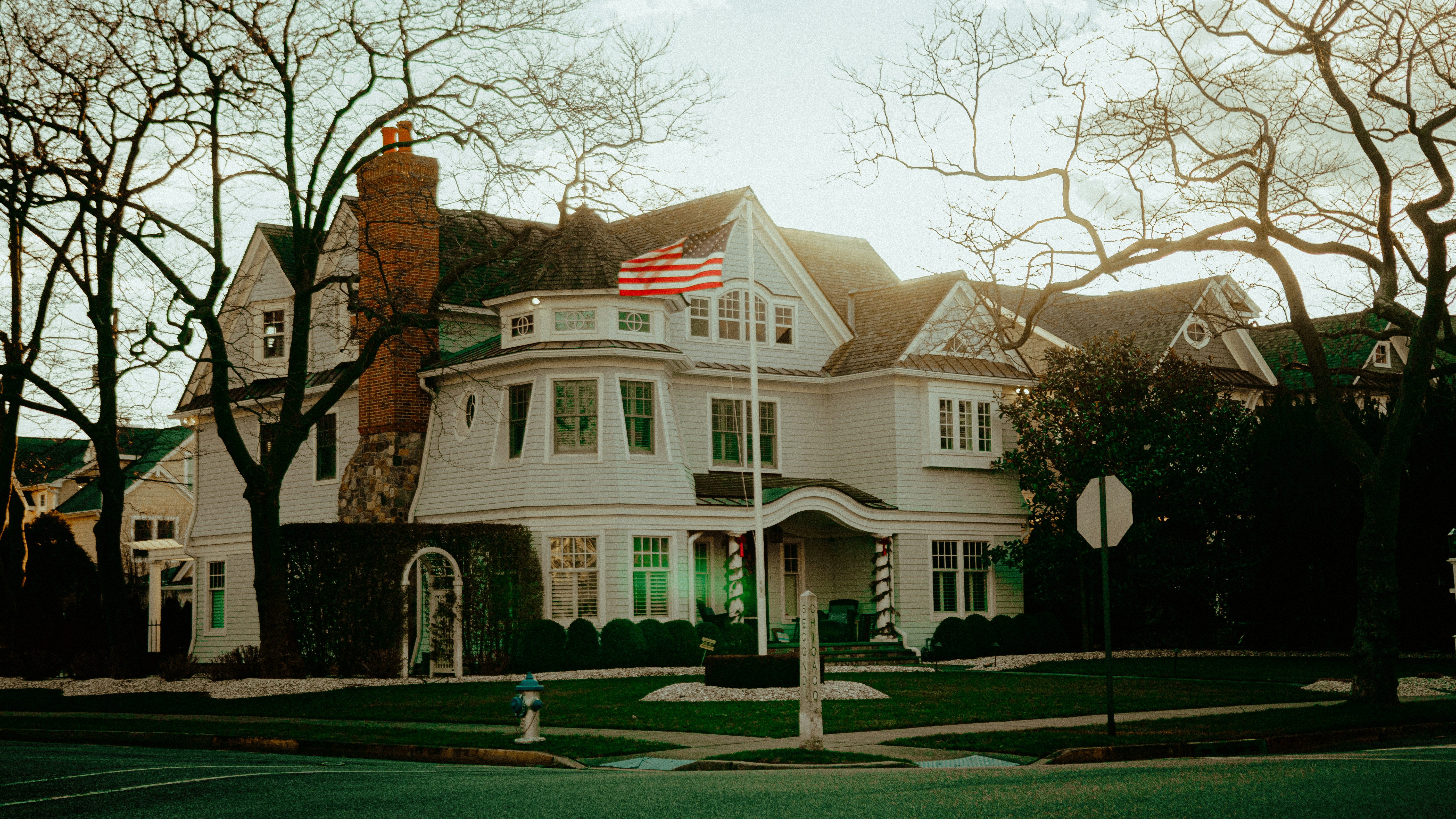 Flag on the White Porch: Sunlit Suburban Facade