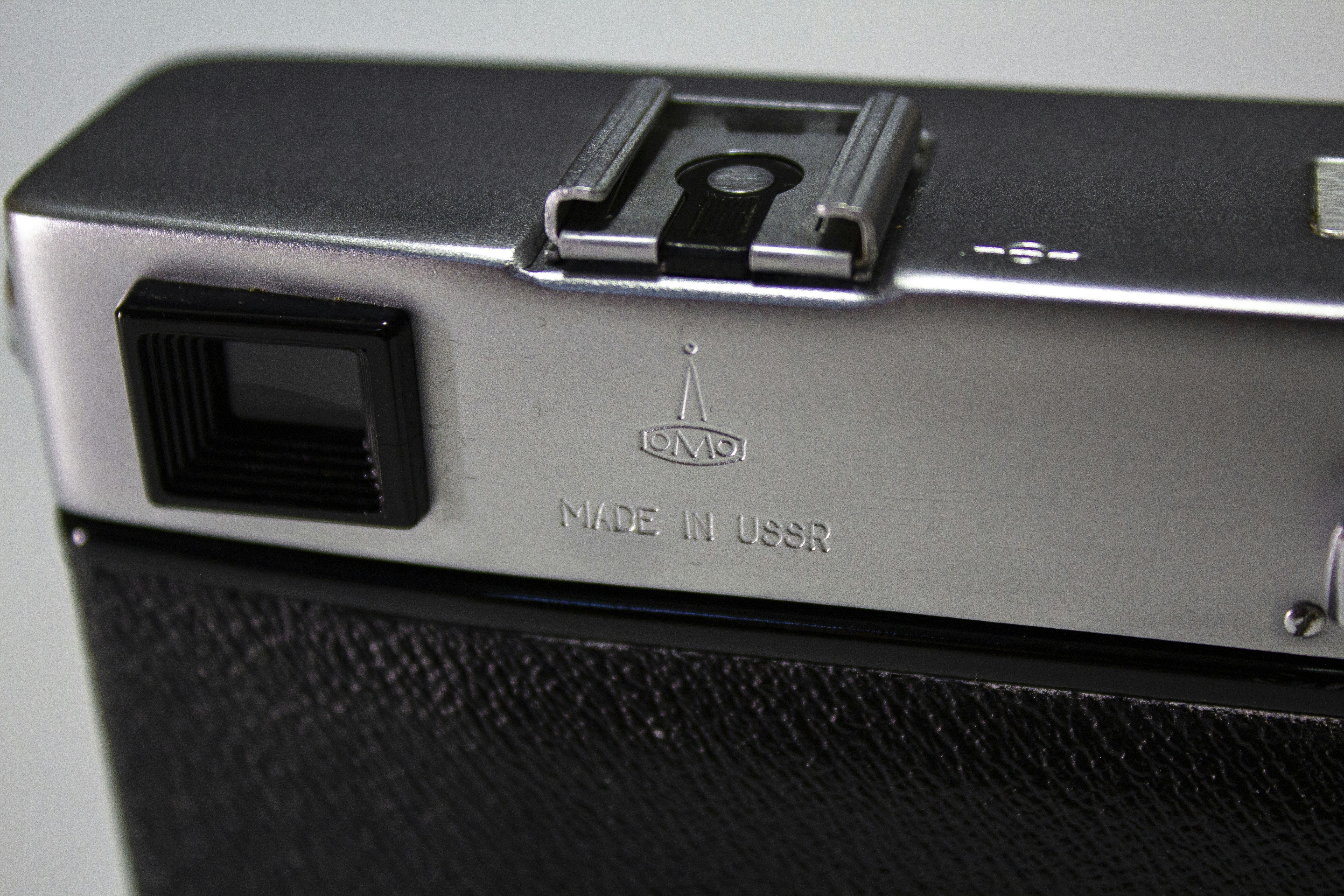 Close-up of a vintage camera showcasing its metallic top and design details, highlighting the inscription 'MADE IN USSR'.