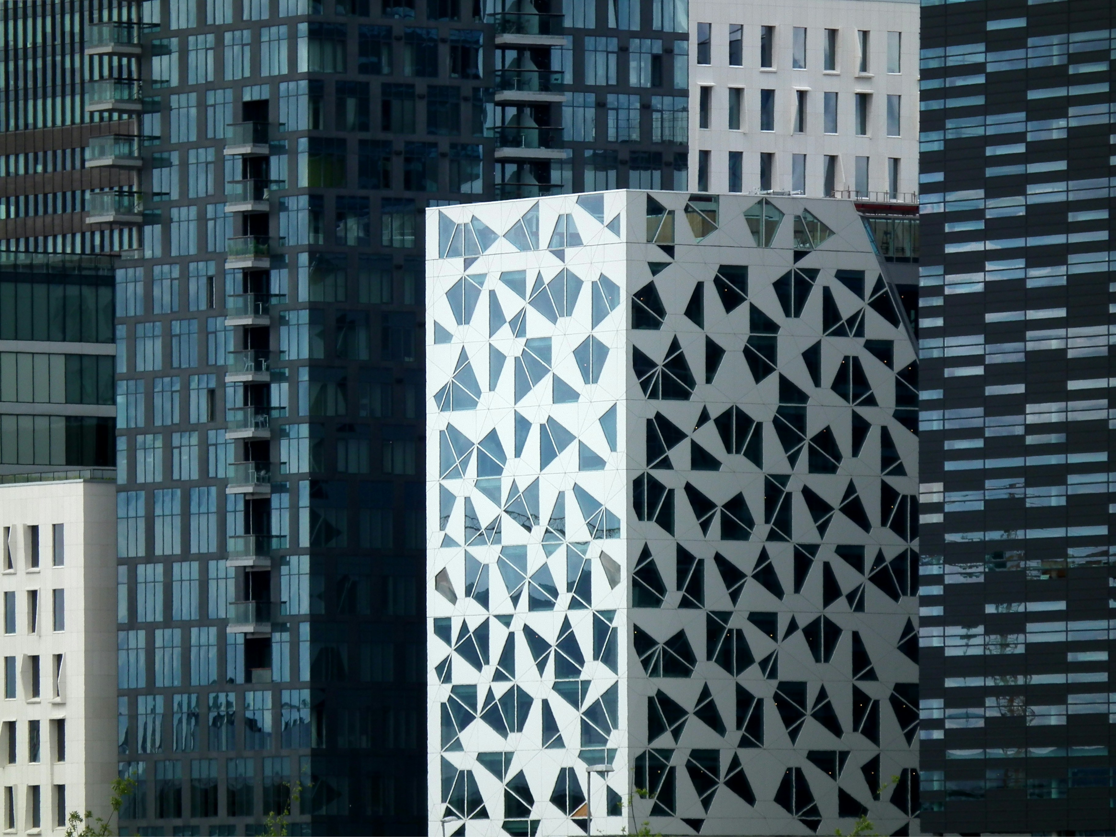 Modern buildings featuring diverse geometric designs and glass facades in a cityscape.