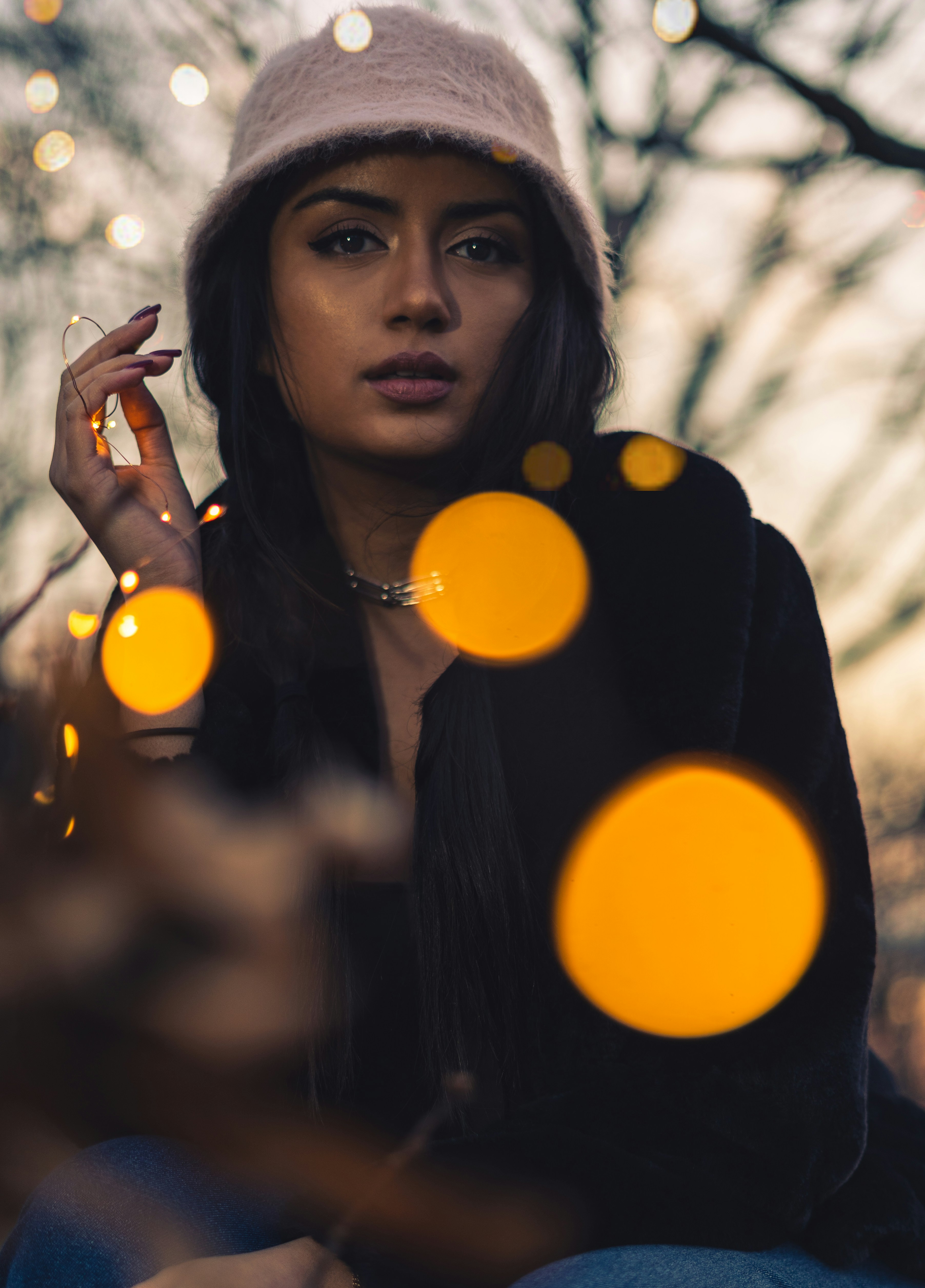 Face in Focus, Lights in Orbit: A Portrait Beneath Golden Orbs