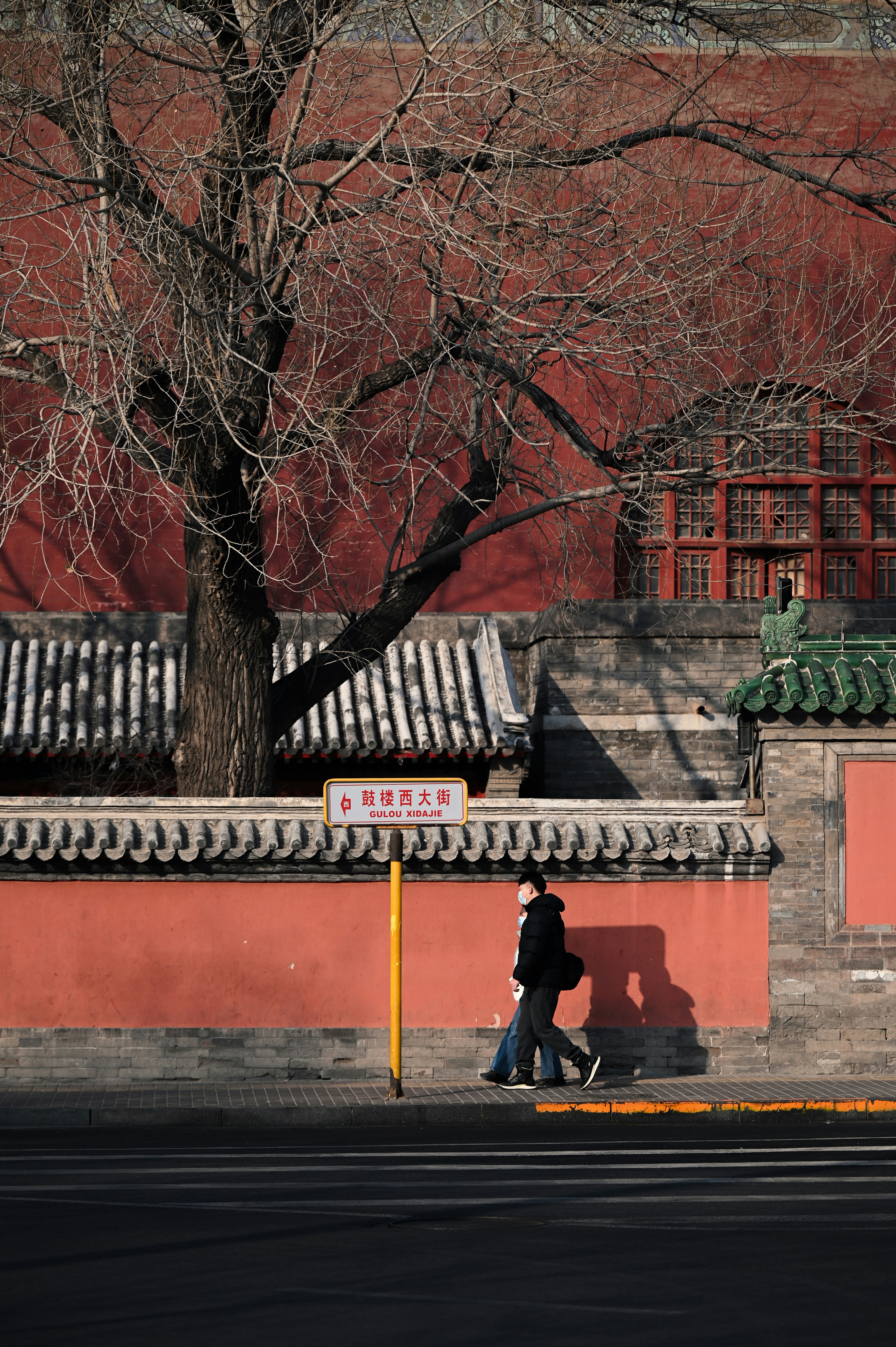 Crimson Wall, Quiet Steps: A Pedestrian in the Shadow of Tradition