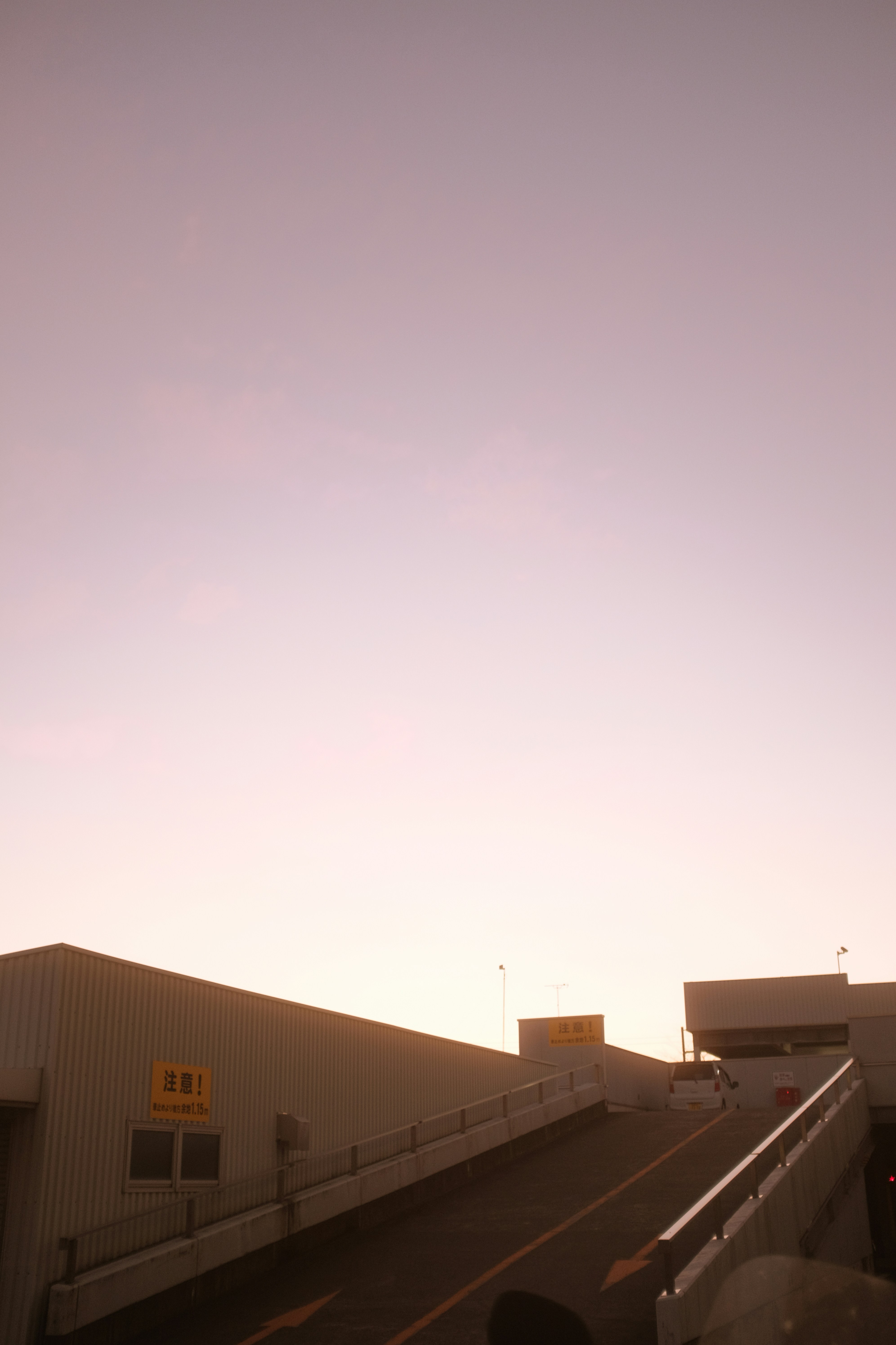 Industrial ramp leading towards a pastel sky at dusk, hinting at the transition from day to night.