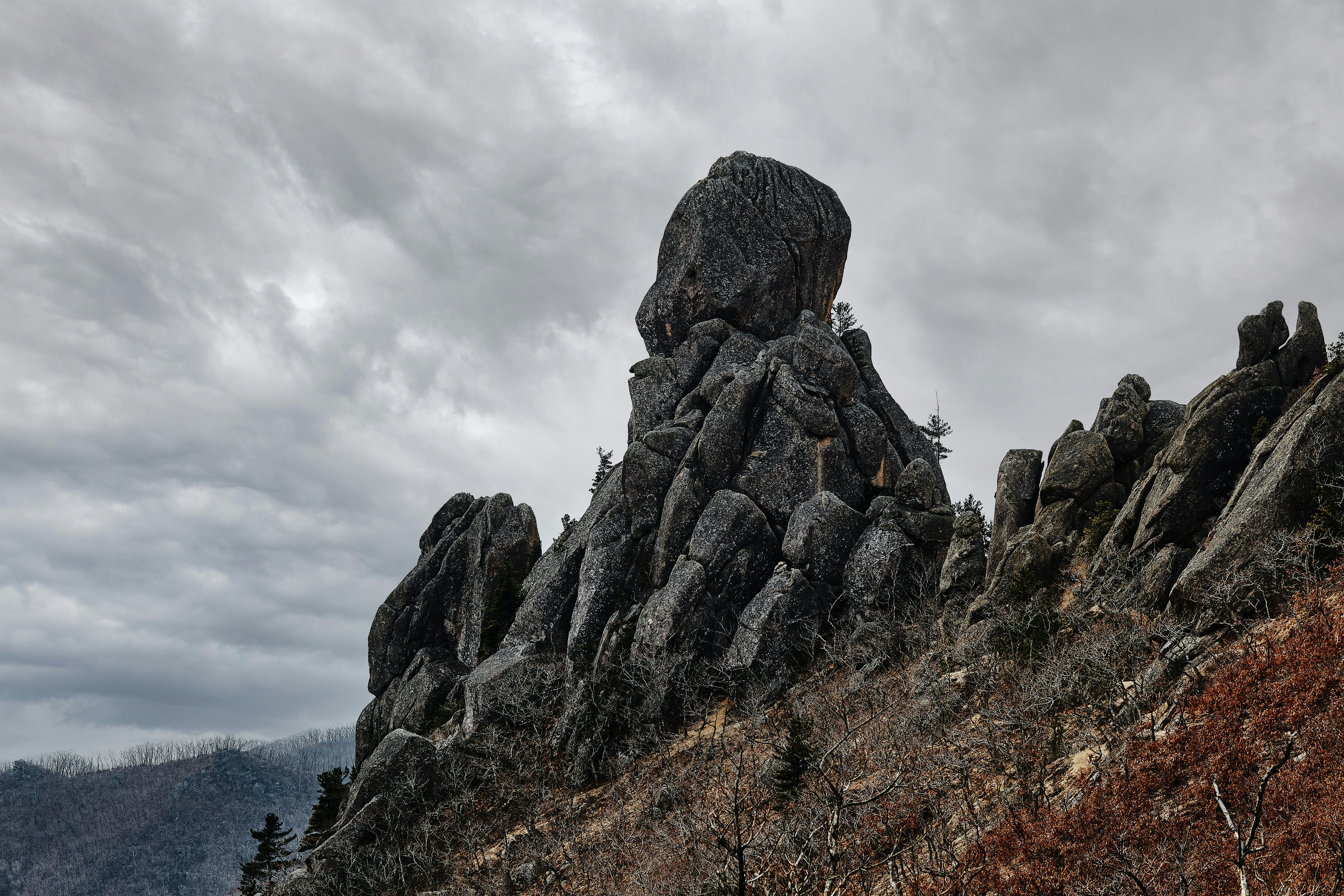 Grim cliffs and gray sky. Beautiful background with dark mountains in Russia