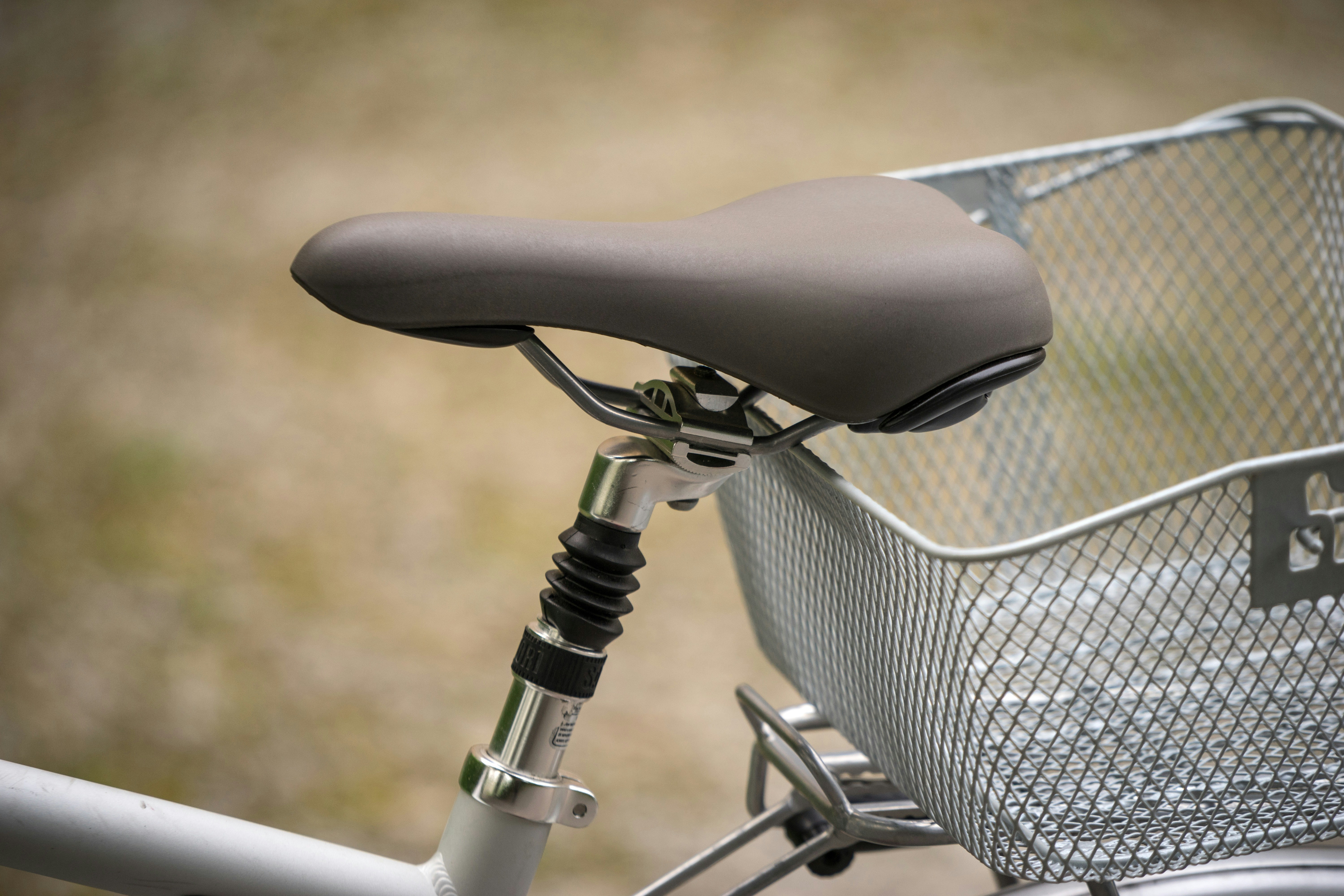 Close-up of a bicycle seat and basket, highlighting ergonomic design and practical features for city commuting.