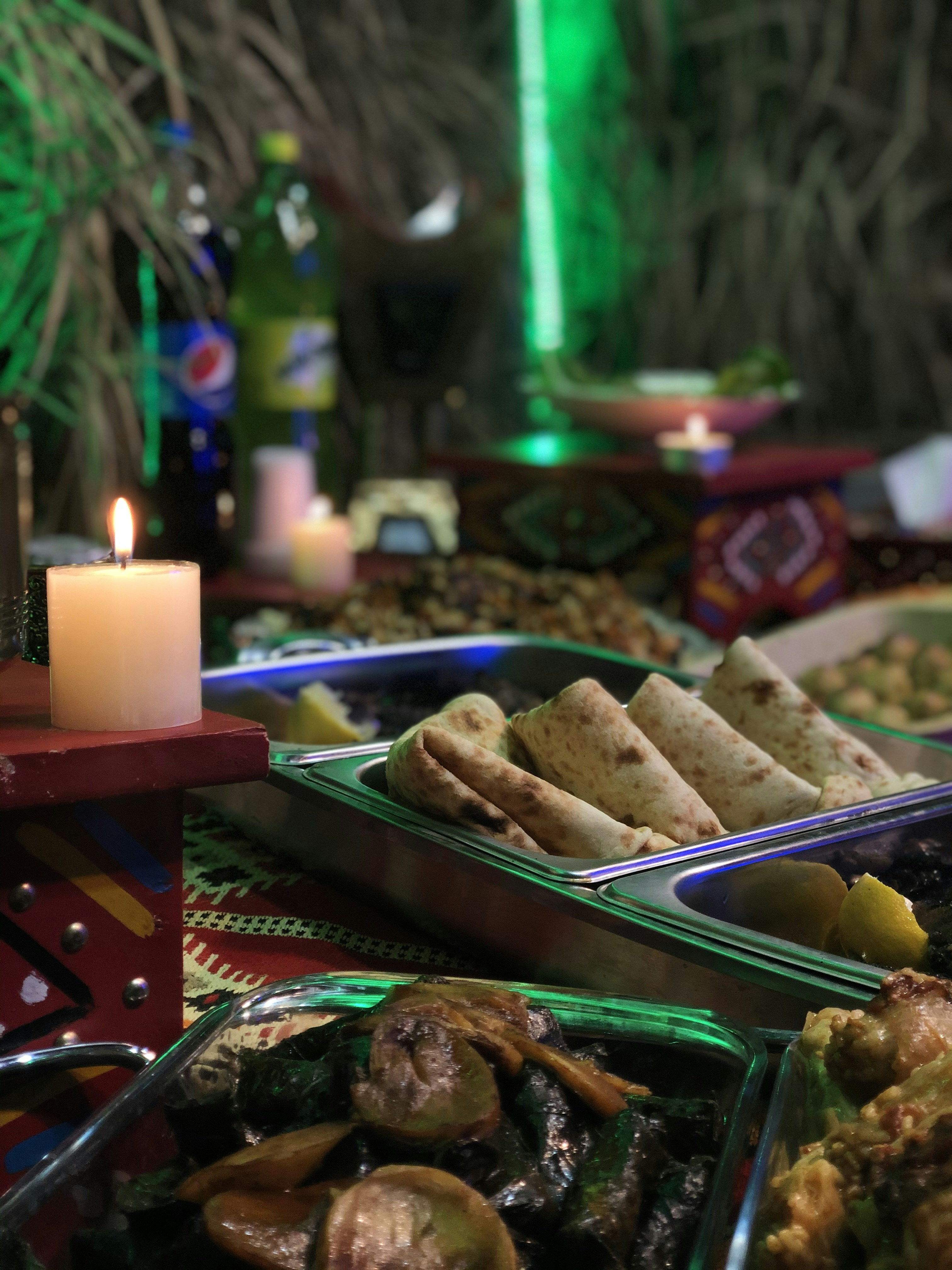 Flame in Focus: Candlelit Buffet Bathed in Emerald Neon Glow