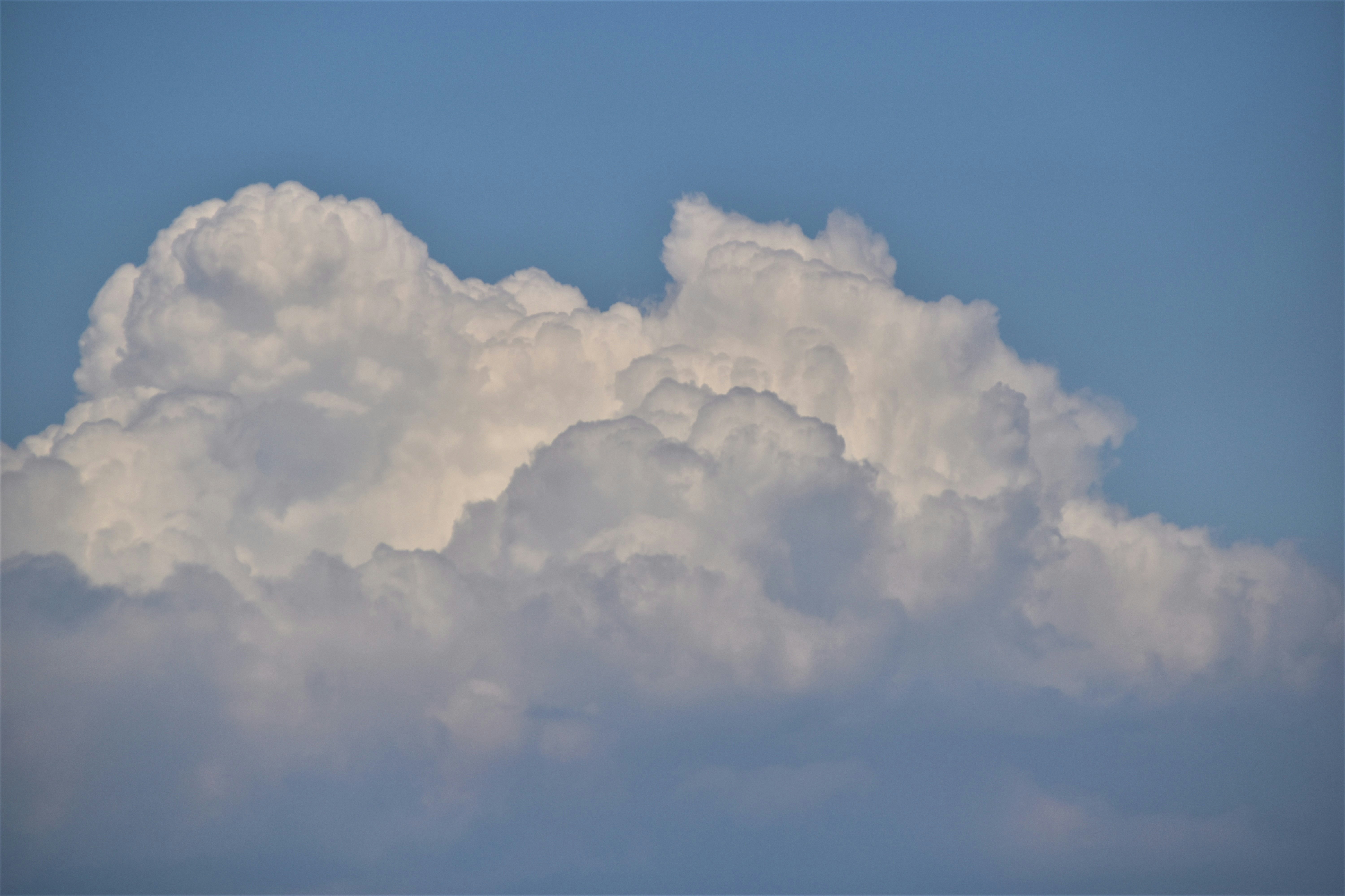 Fluffy white clouds gently layered against a serene blue sky, creating a tranquil atmosphere.