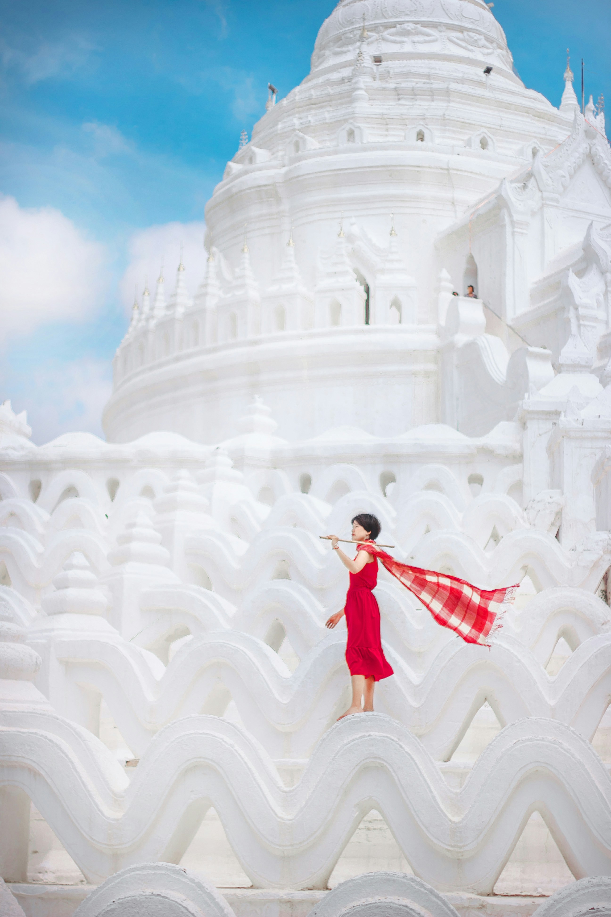 man in red long sleeve shirt standing on white concrete building during daytime