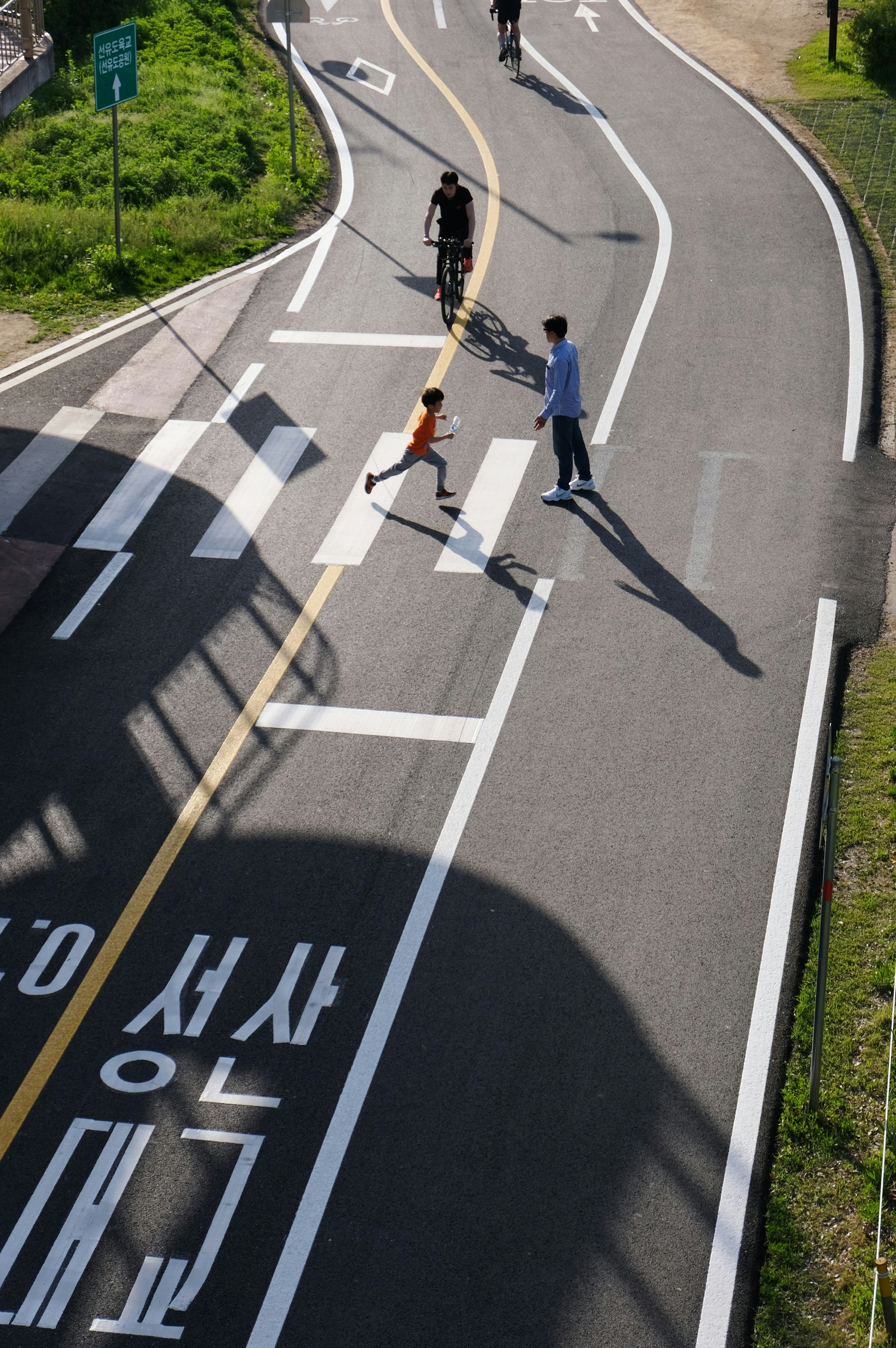 Crosswalk Dance: A Child's Sprint Through a Sunlit Urban Path