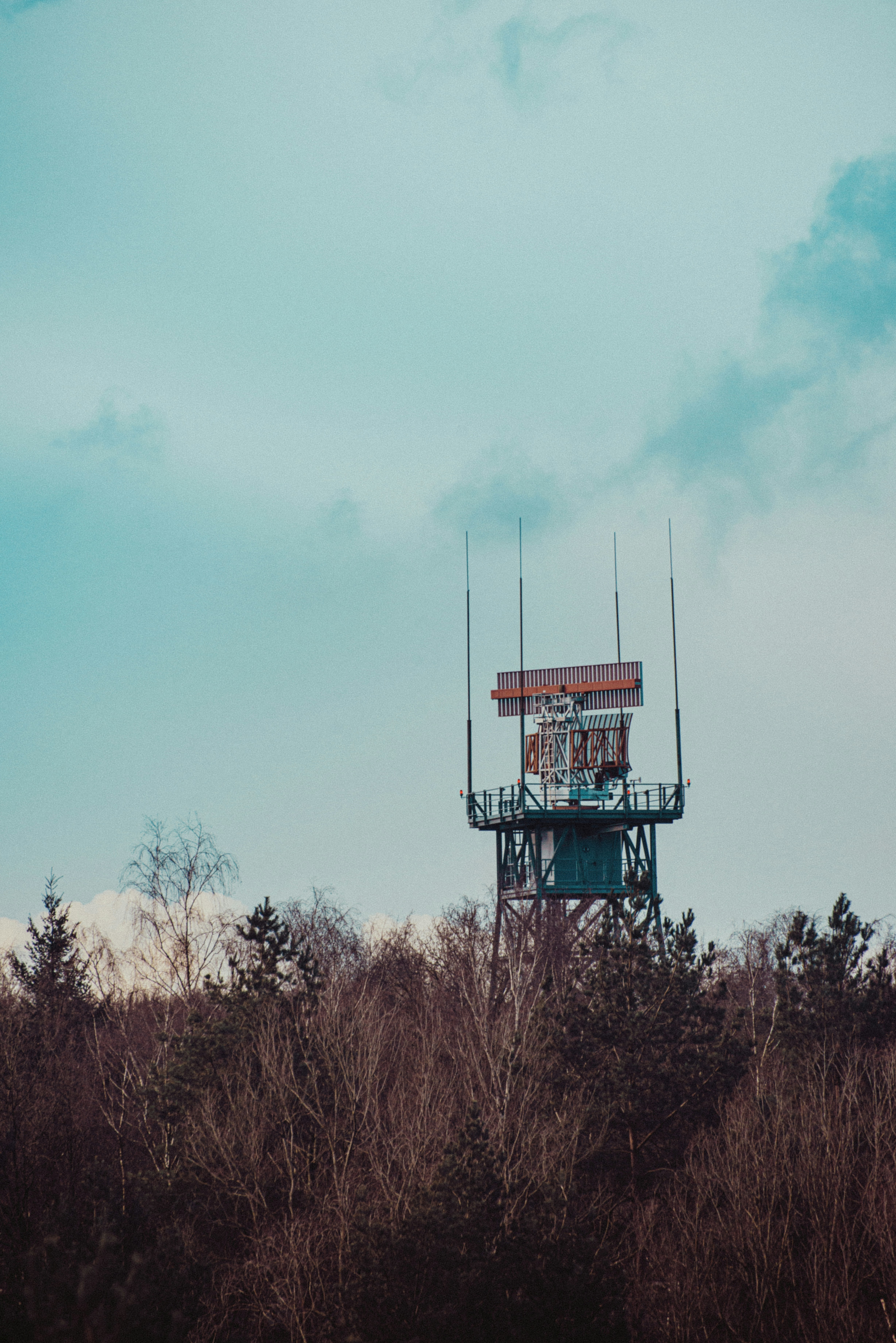 Military radar in the forest. | red and white metal frame