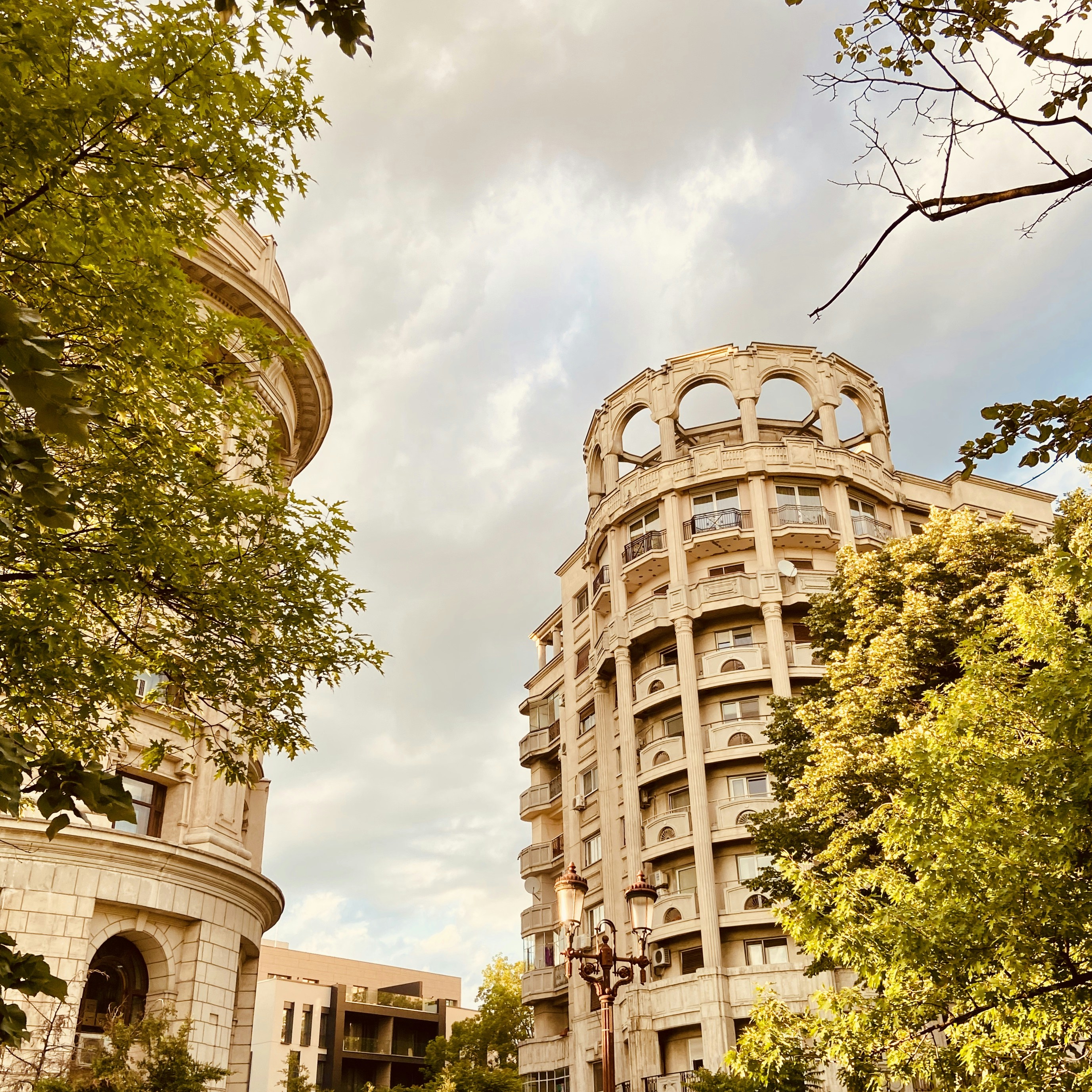 Architectural marvels framed by lush greenery under a dynamic sky.