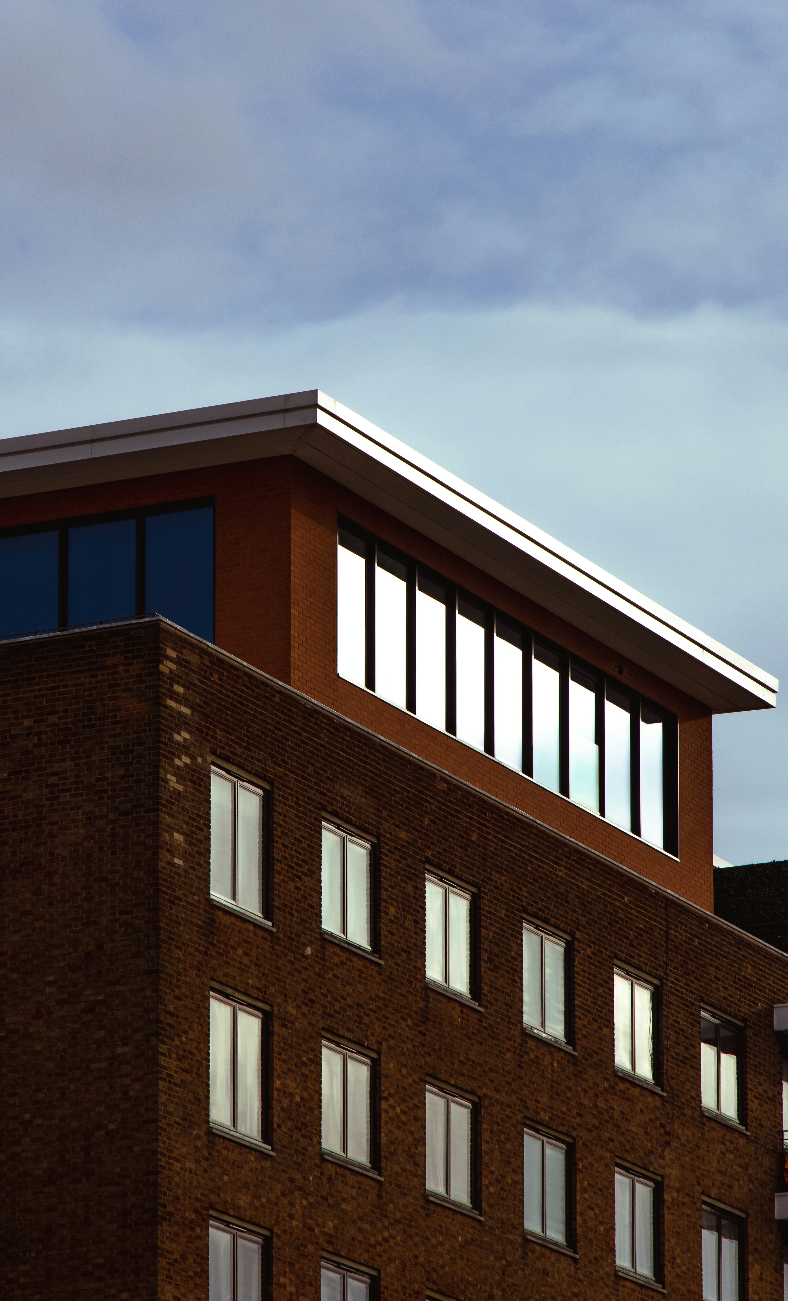 Brick Crown: top-floor windows frame a quiet sky