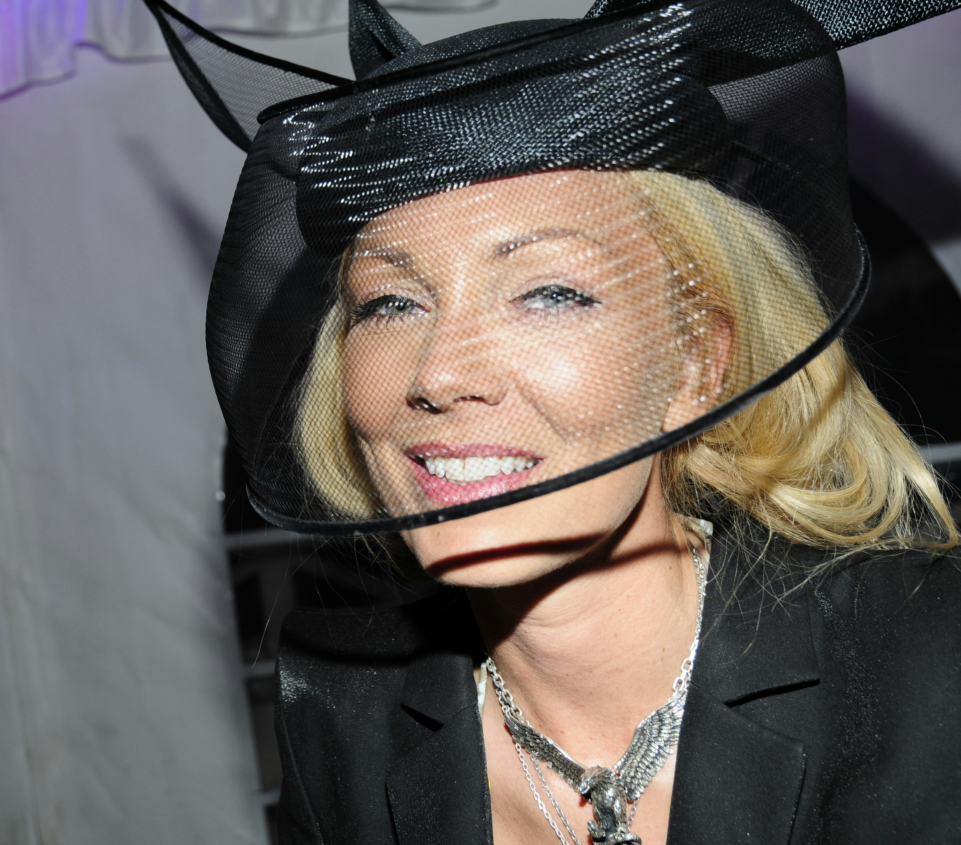 Veiled Grin at the Gala: Blonde in a Black Mesh Hat
