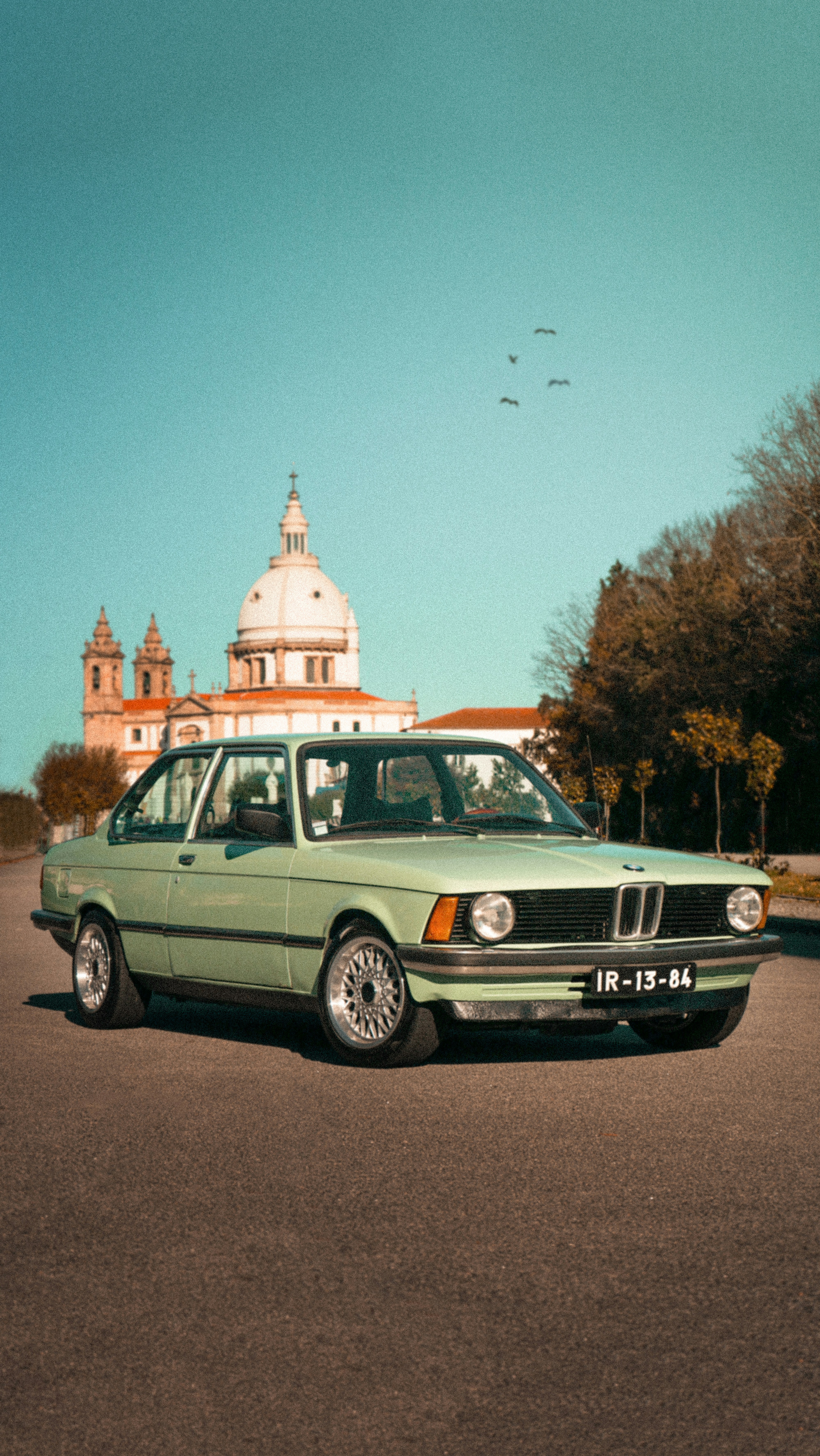Mint-Colored Vintage BMW Posed Before a Baroque Dome in a Sunlit Square