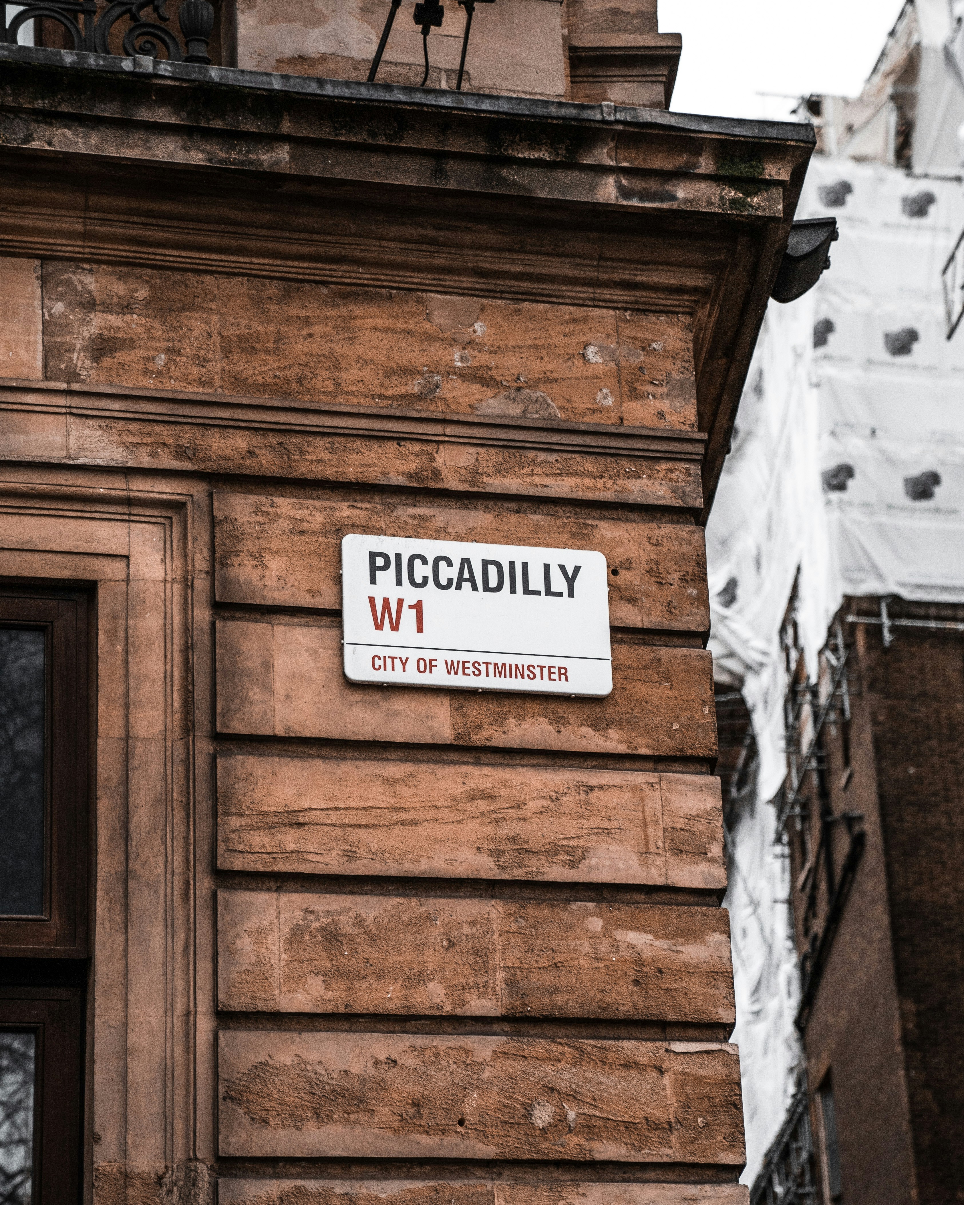 Piccadilly Signpost on Weathered Red Brick Facade