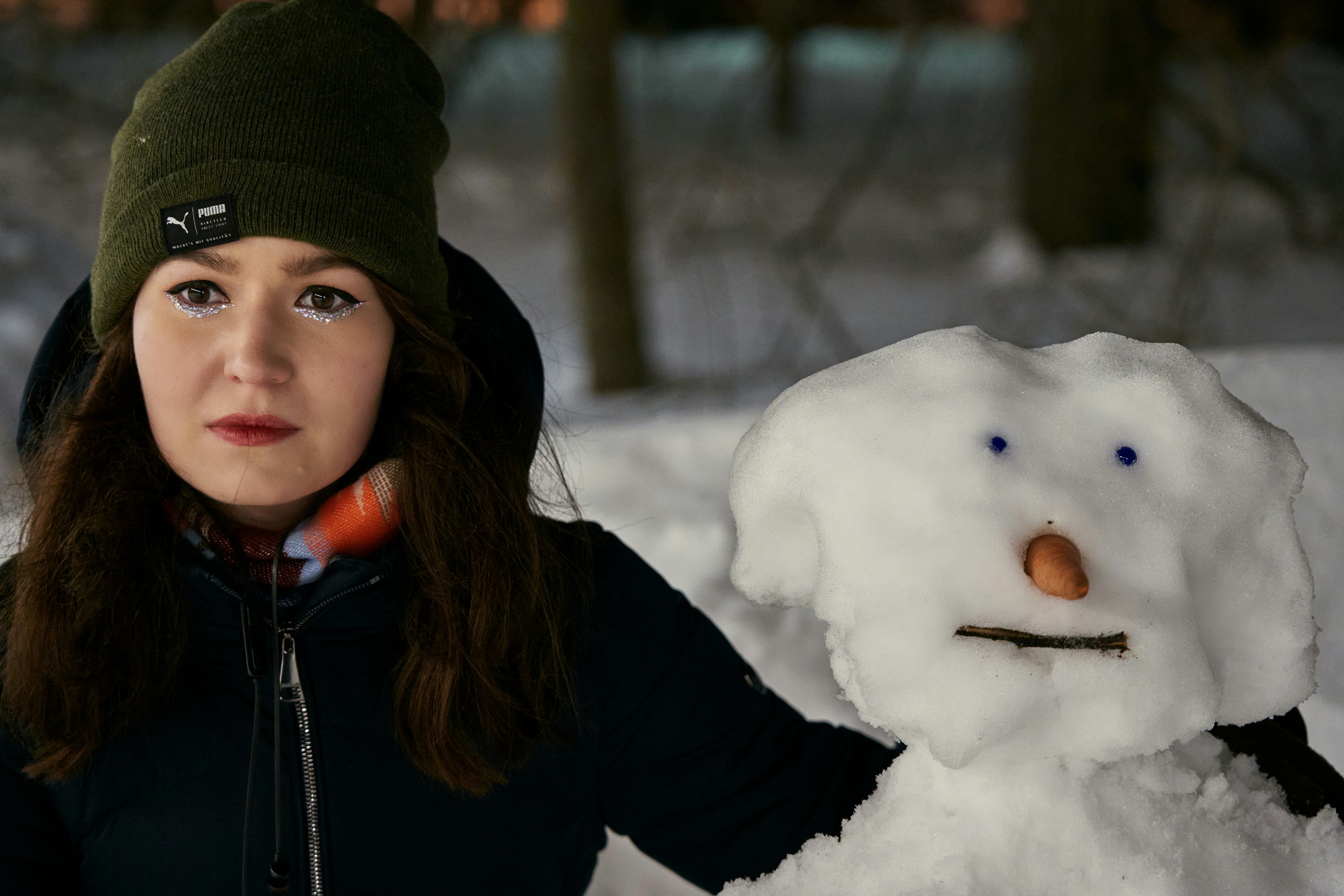 Winter Portrait in Pine Shadows: Girl Beside a Handcrafted Snowman
