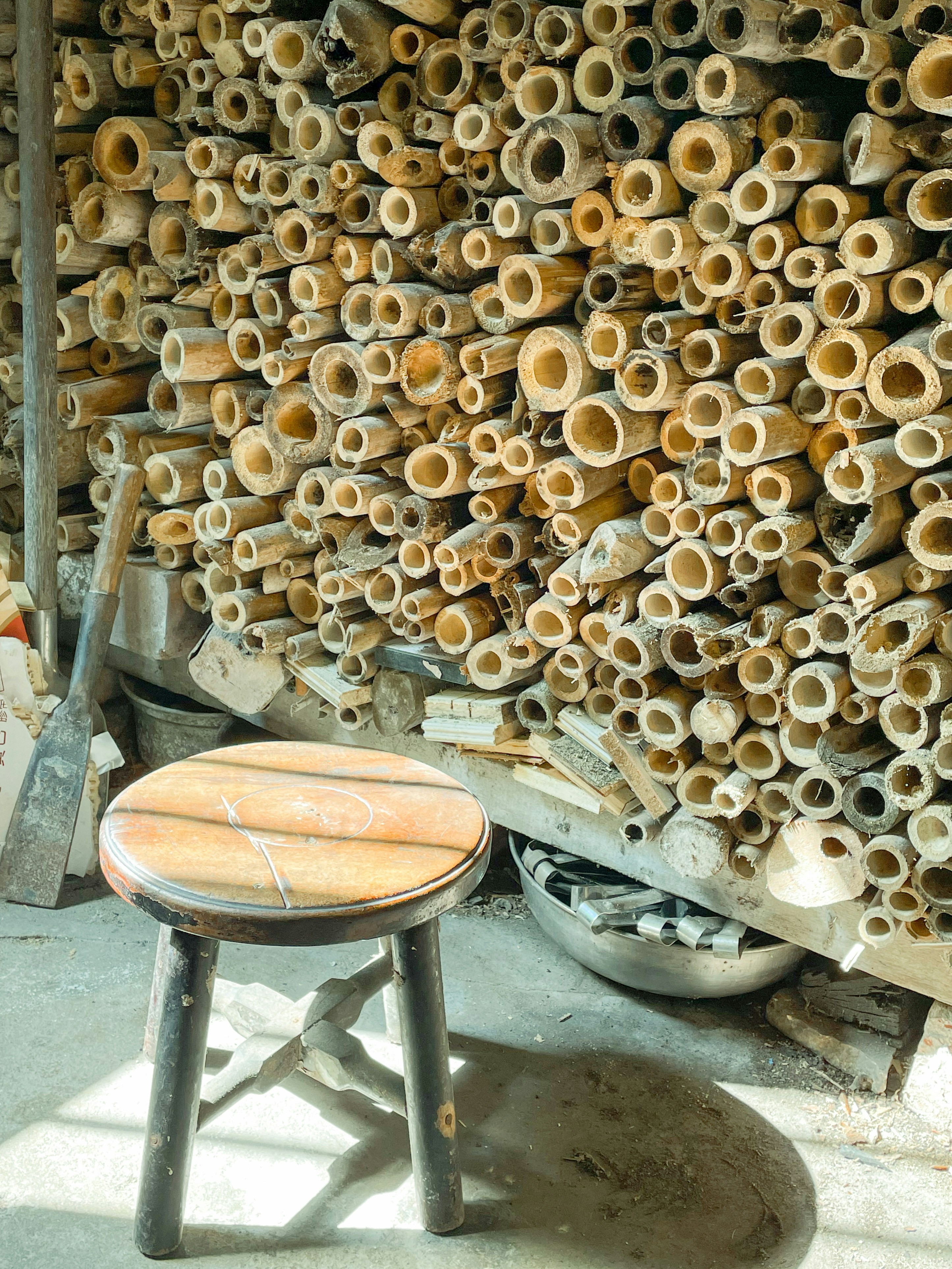 Aged Bamboo Tubes Create Textured Backdrop for a Weathered Workshop Stool