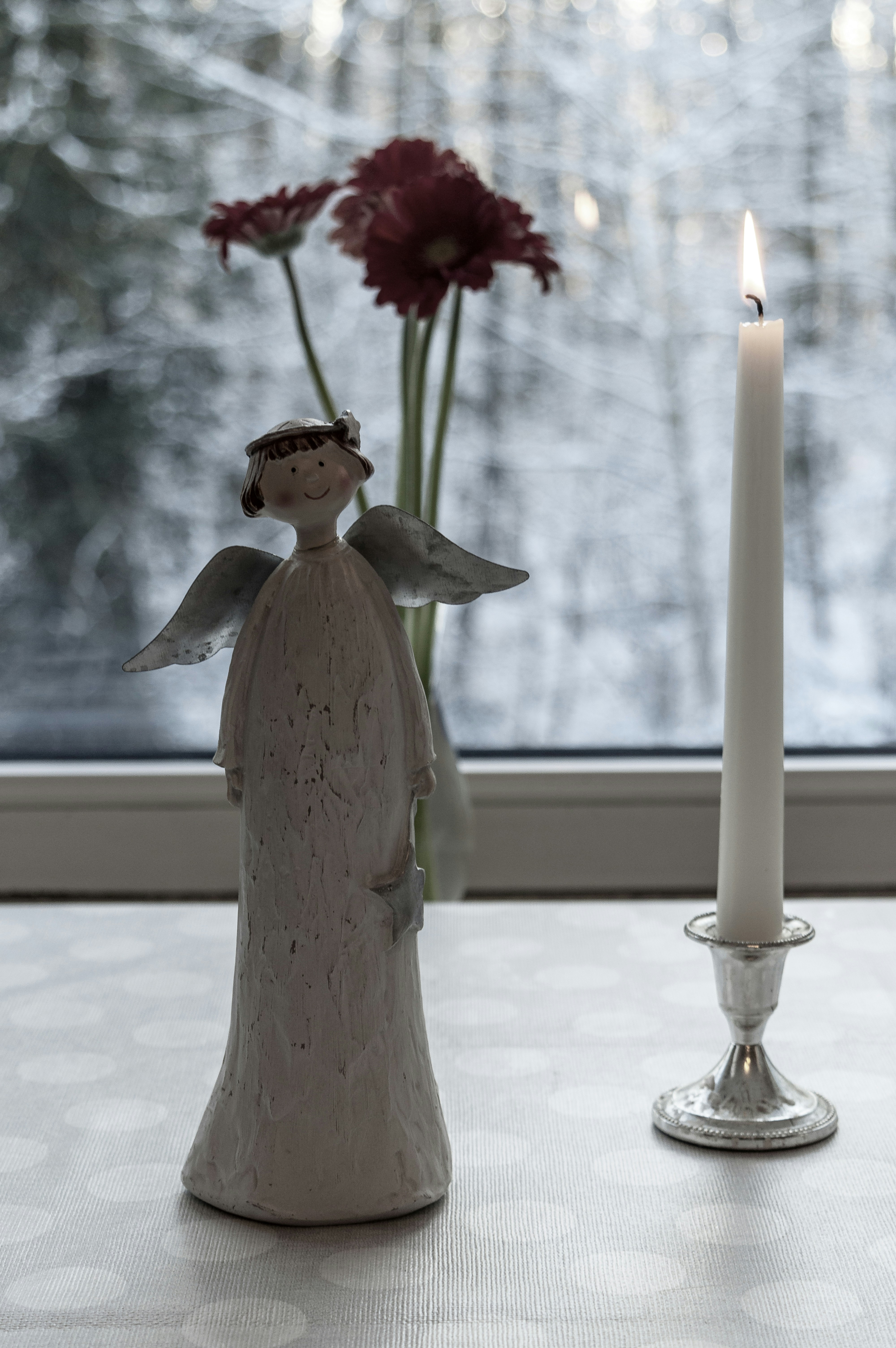 Ceramic Angel in Candlelight: A Winter Tabletop Still Life