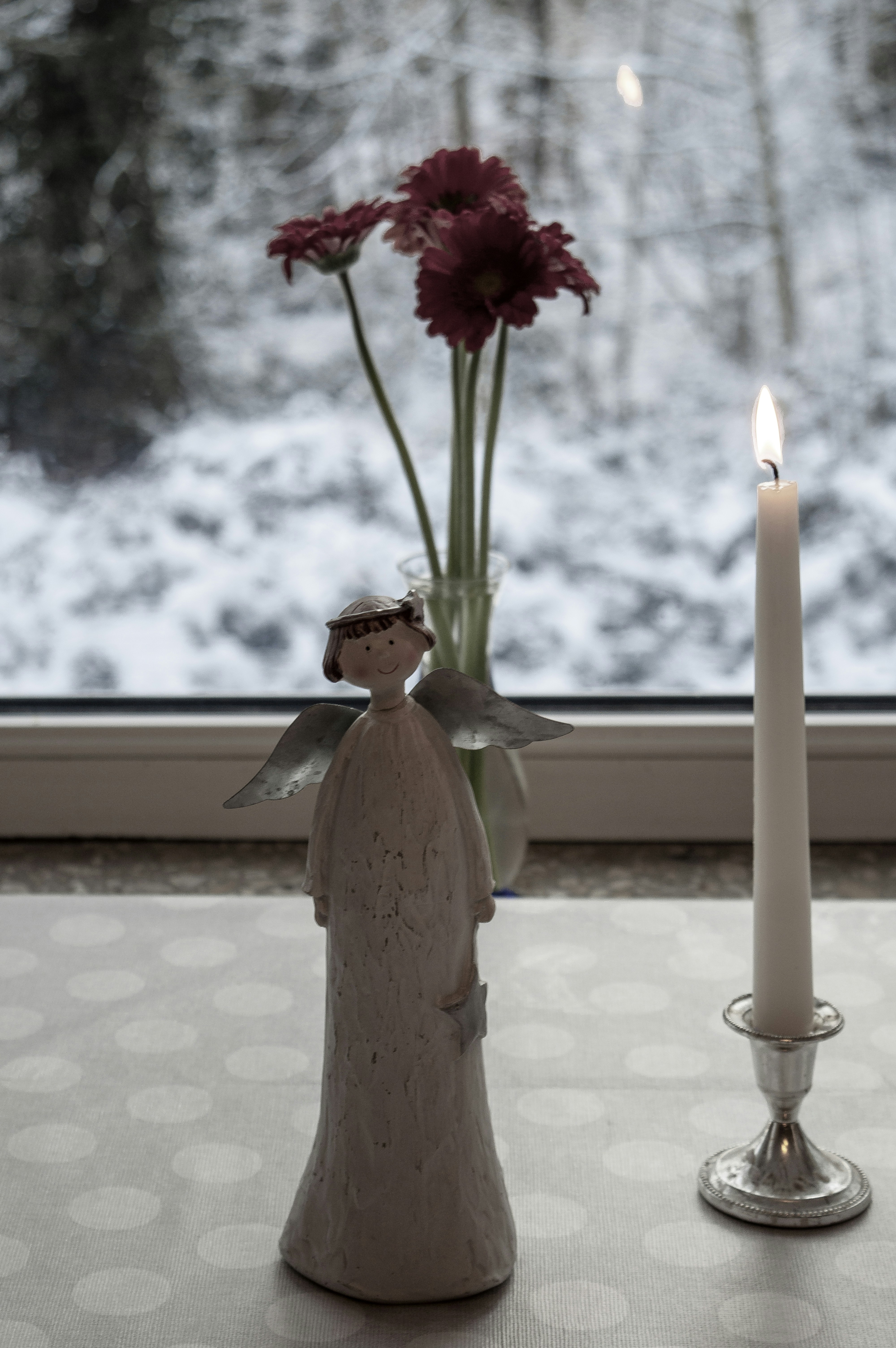 Candles and Ceramic Angel on a Snowy Window Sill