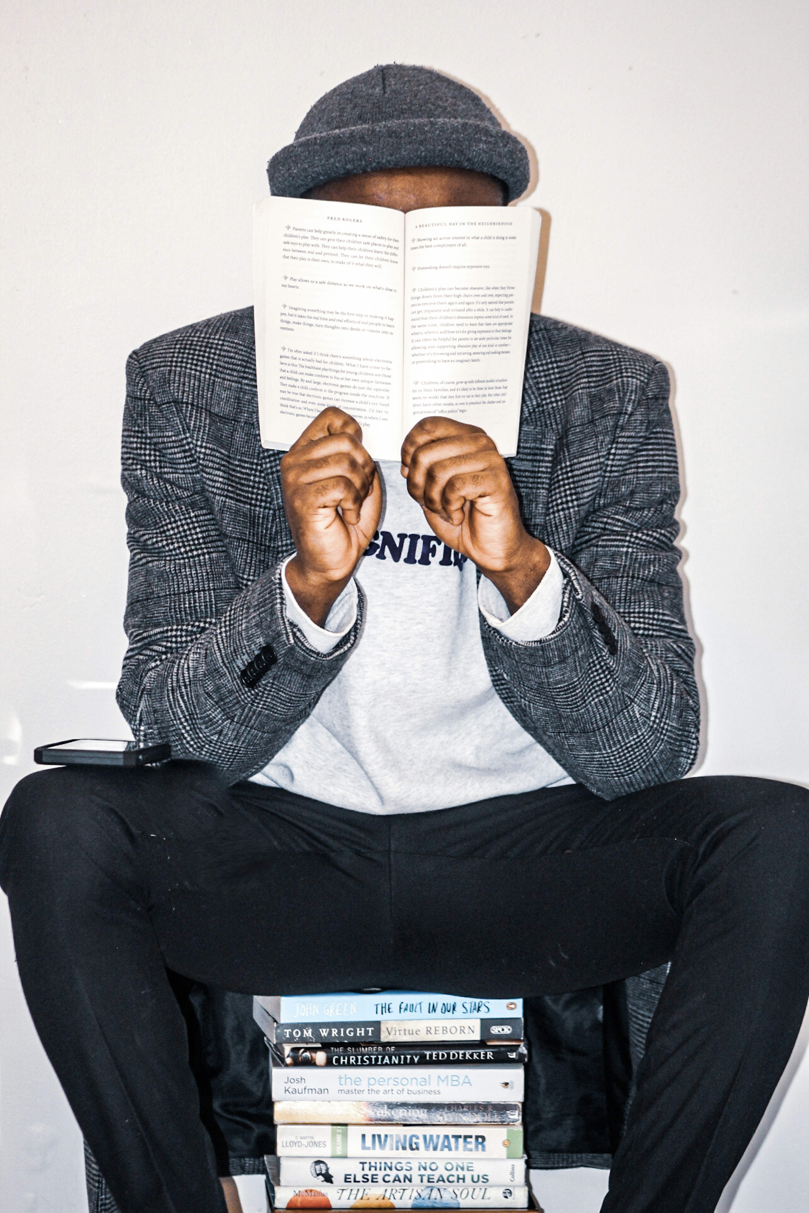 Reader in Shade: A Man with an Open Book Cloaked in Page-Beneath Quiet Intent