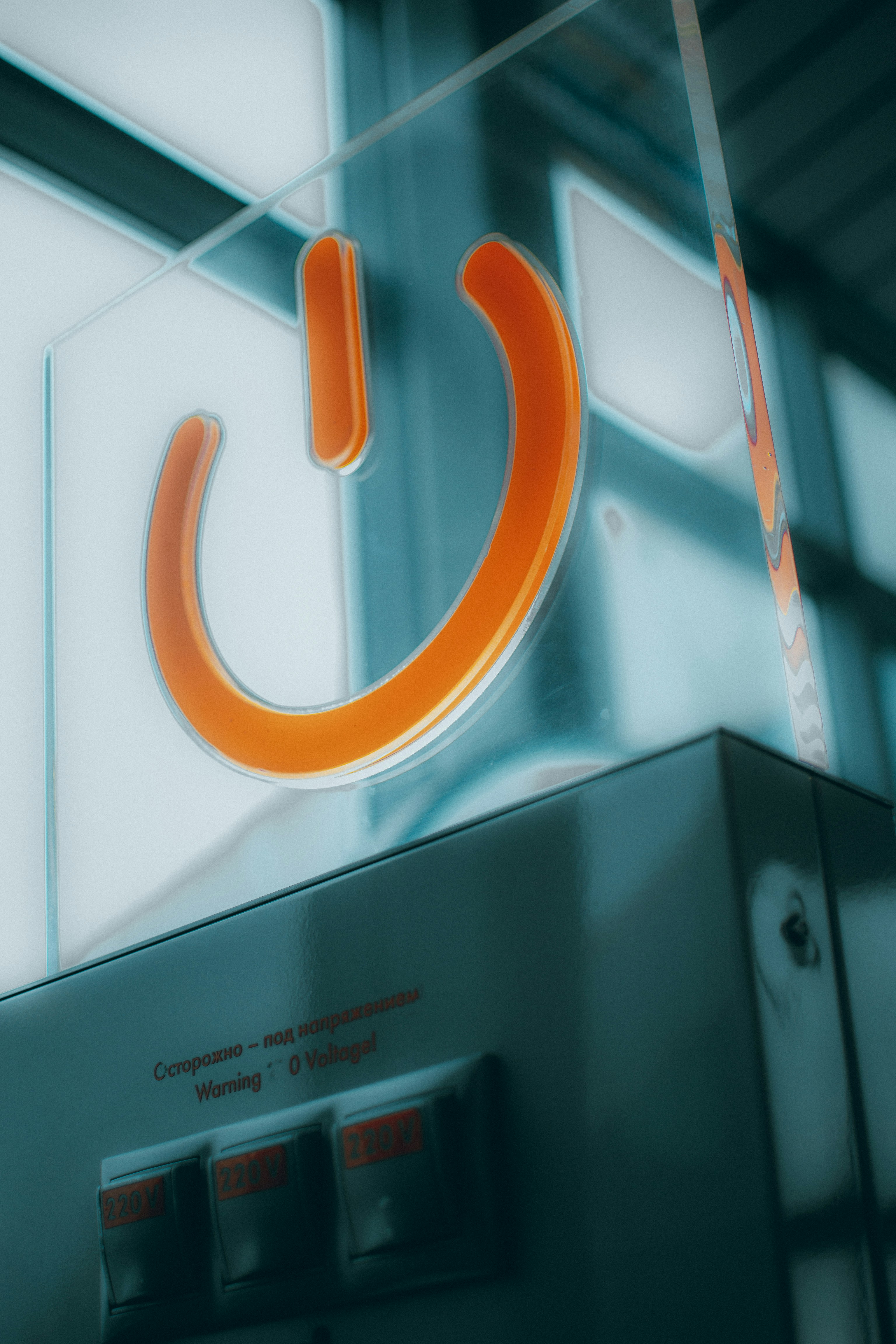 Arc of Orange on Glass: A Quiet Moment of Urban Signage