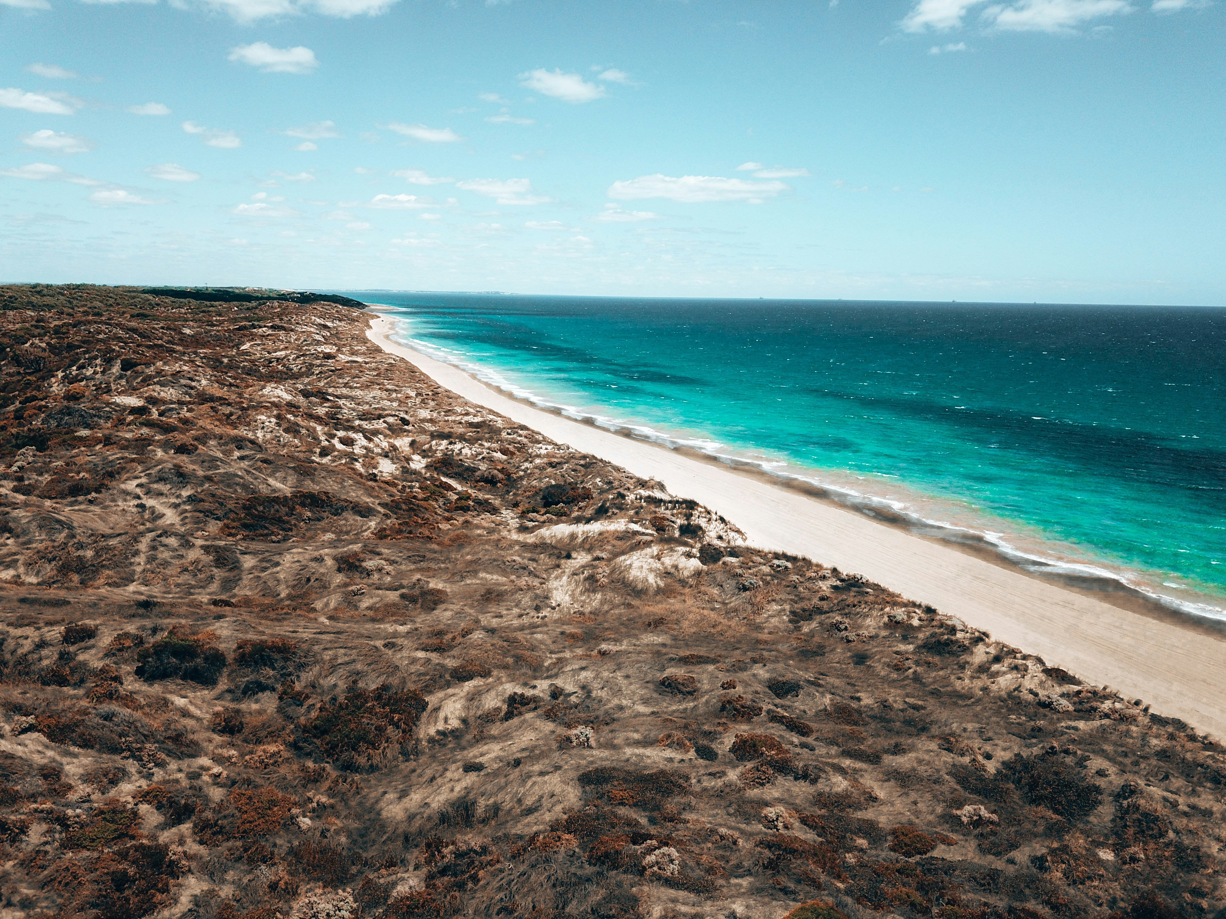Coastal Quiet: A Windswept Dune Line Meeting Turquoise Sea