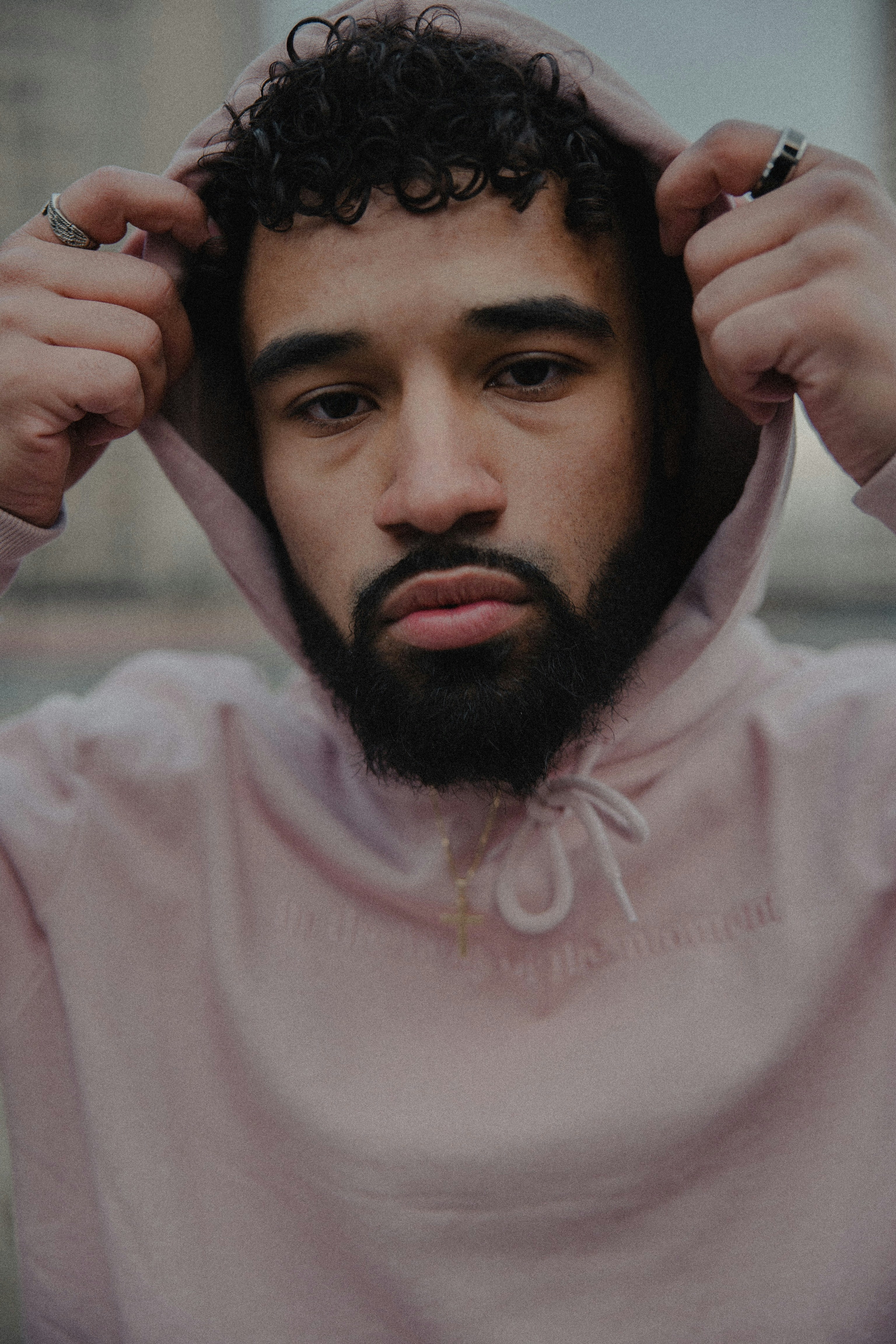 Pink Hoodie Portrait: Contemplative Moment in Soft Urban Light