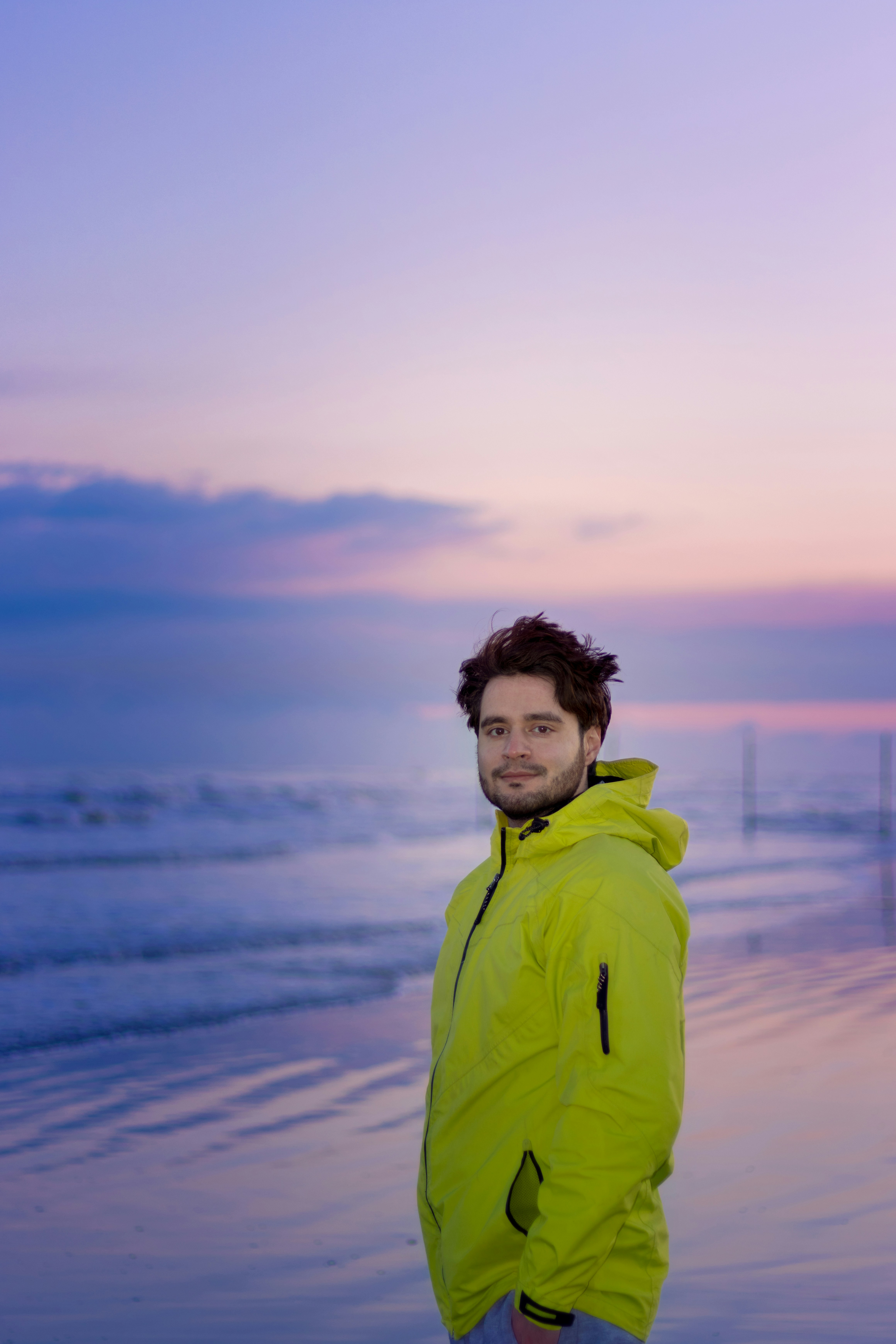 Man in yellow hoodie standing on snow covered ground during daytime ...
