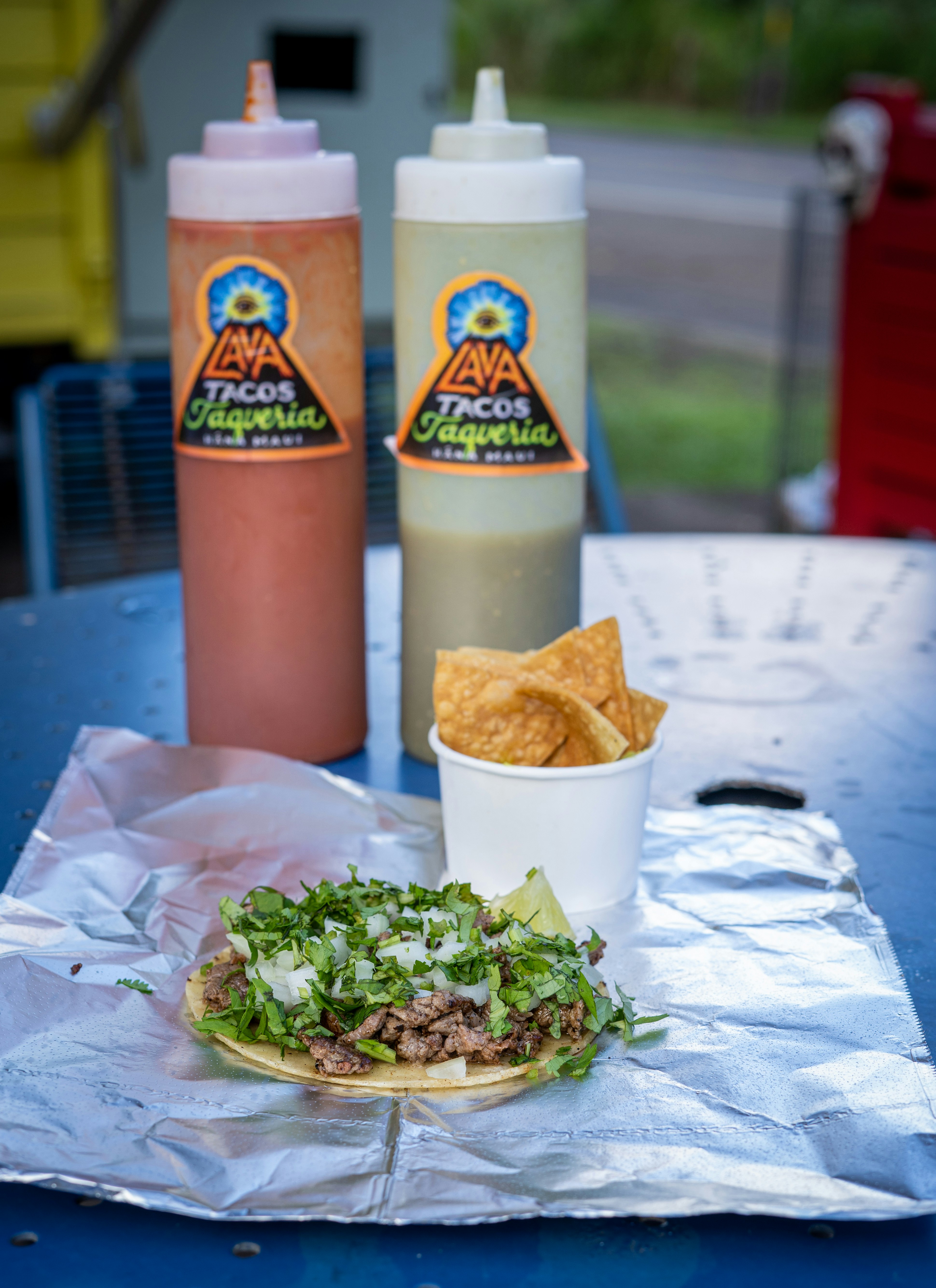 Taco Stand Portrait: A Taco, Salsa Bottles, and Chips