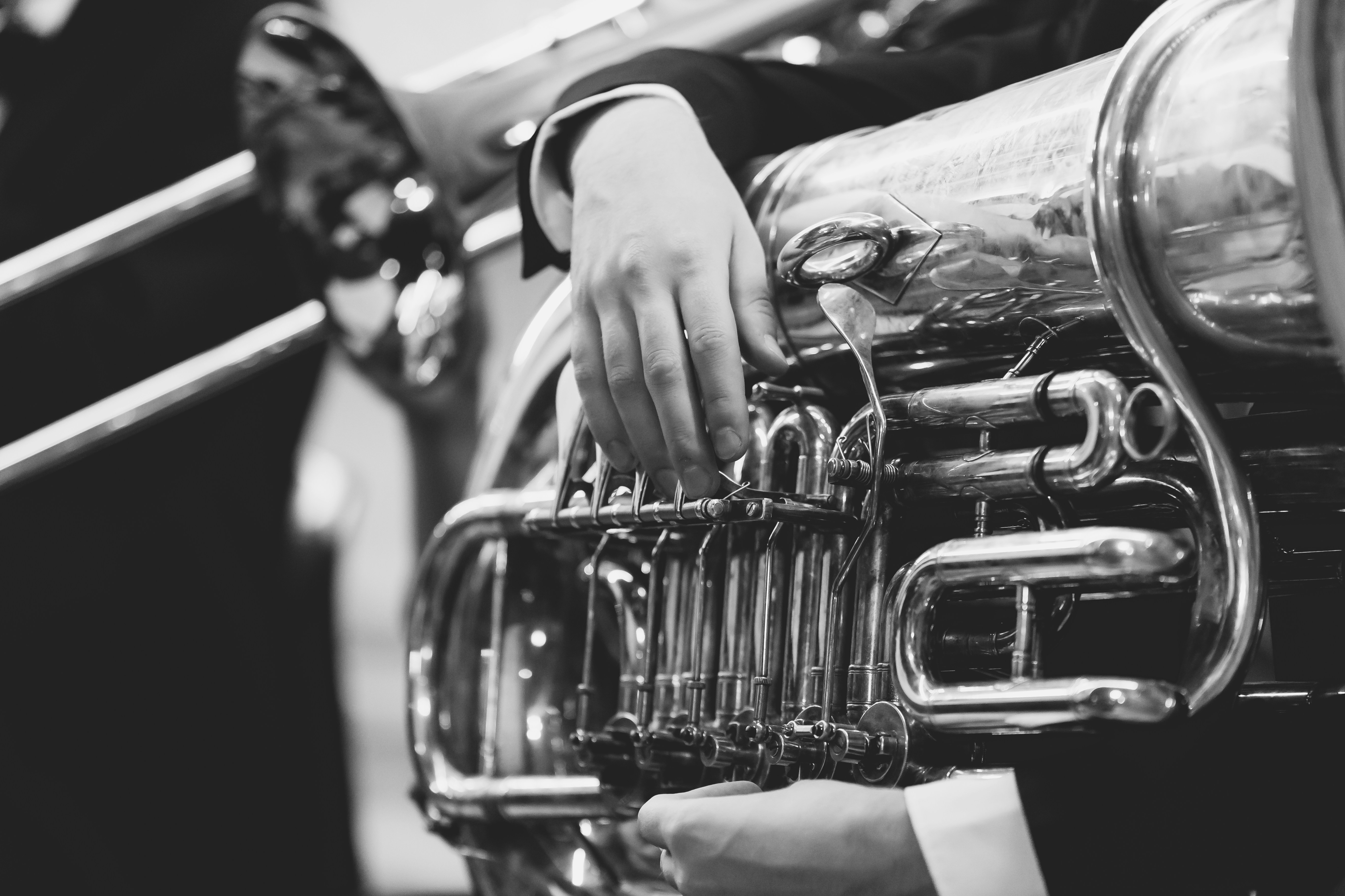 Close-up of a musician's hands playing a brass instrument during a performance.