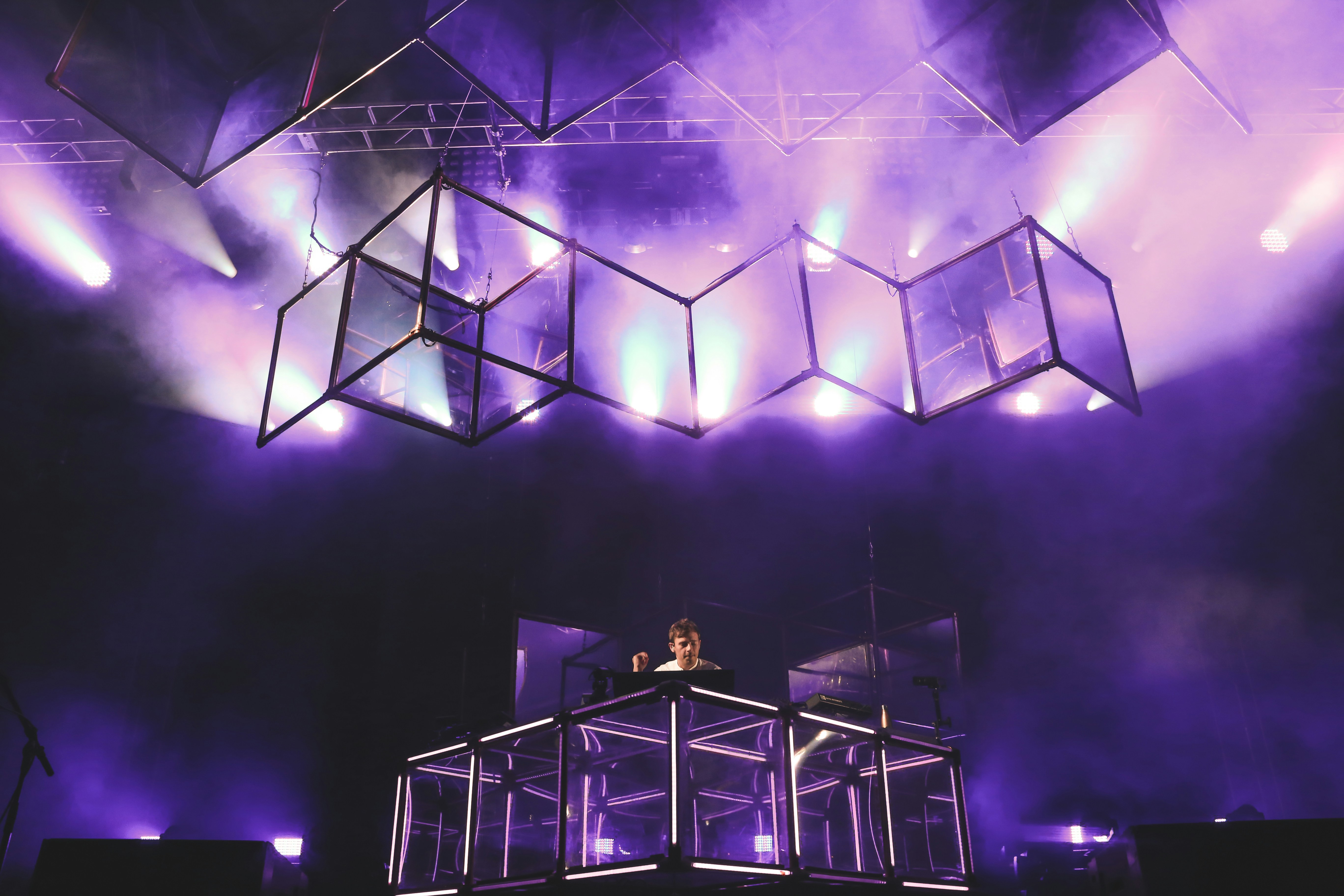 Geometric Neon Overstage: The DJ Beneath Floating Cube Lattices
