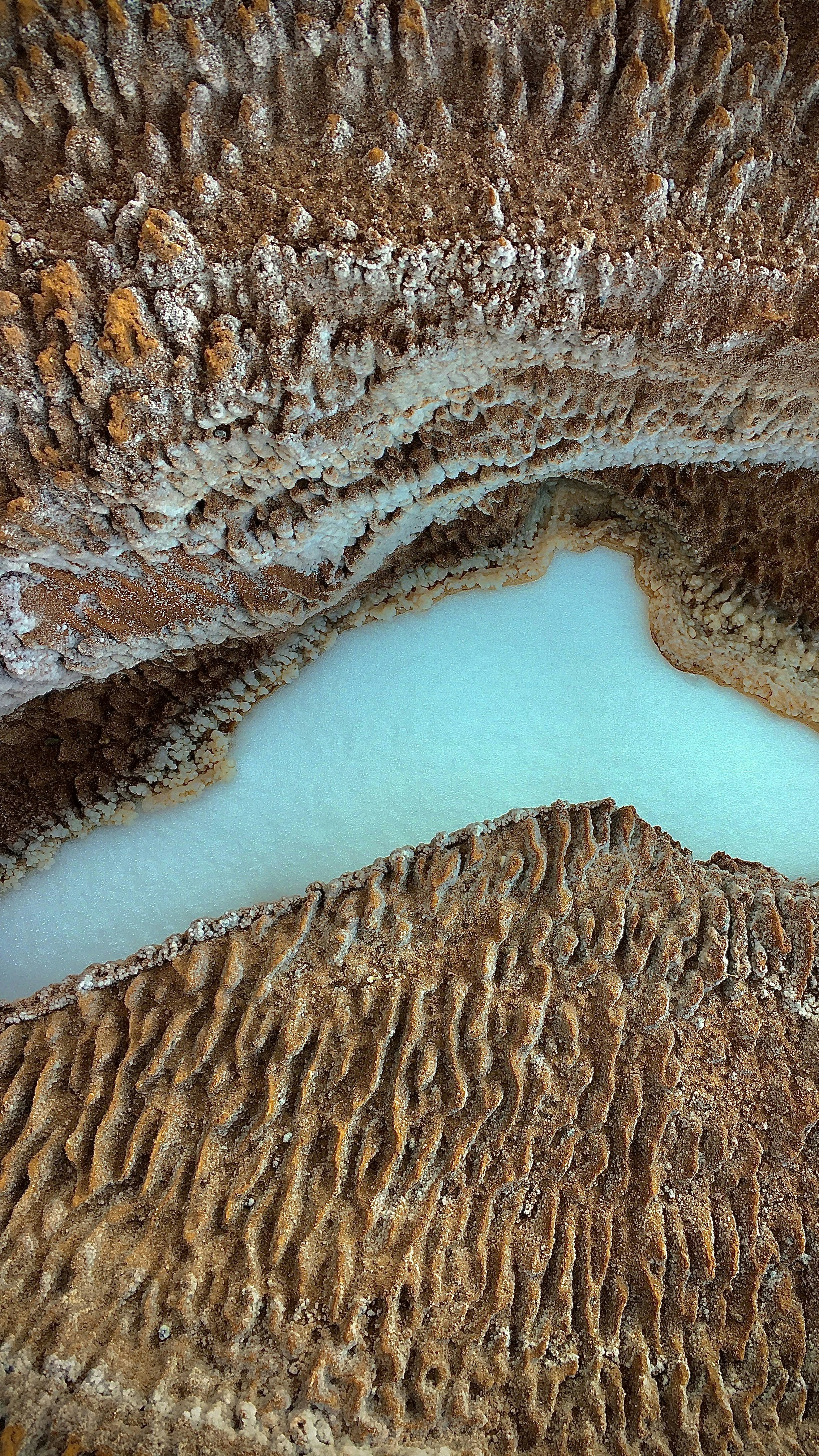 Close-up of textured limestone formations surrounding a pool of turquoise water.