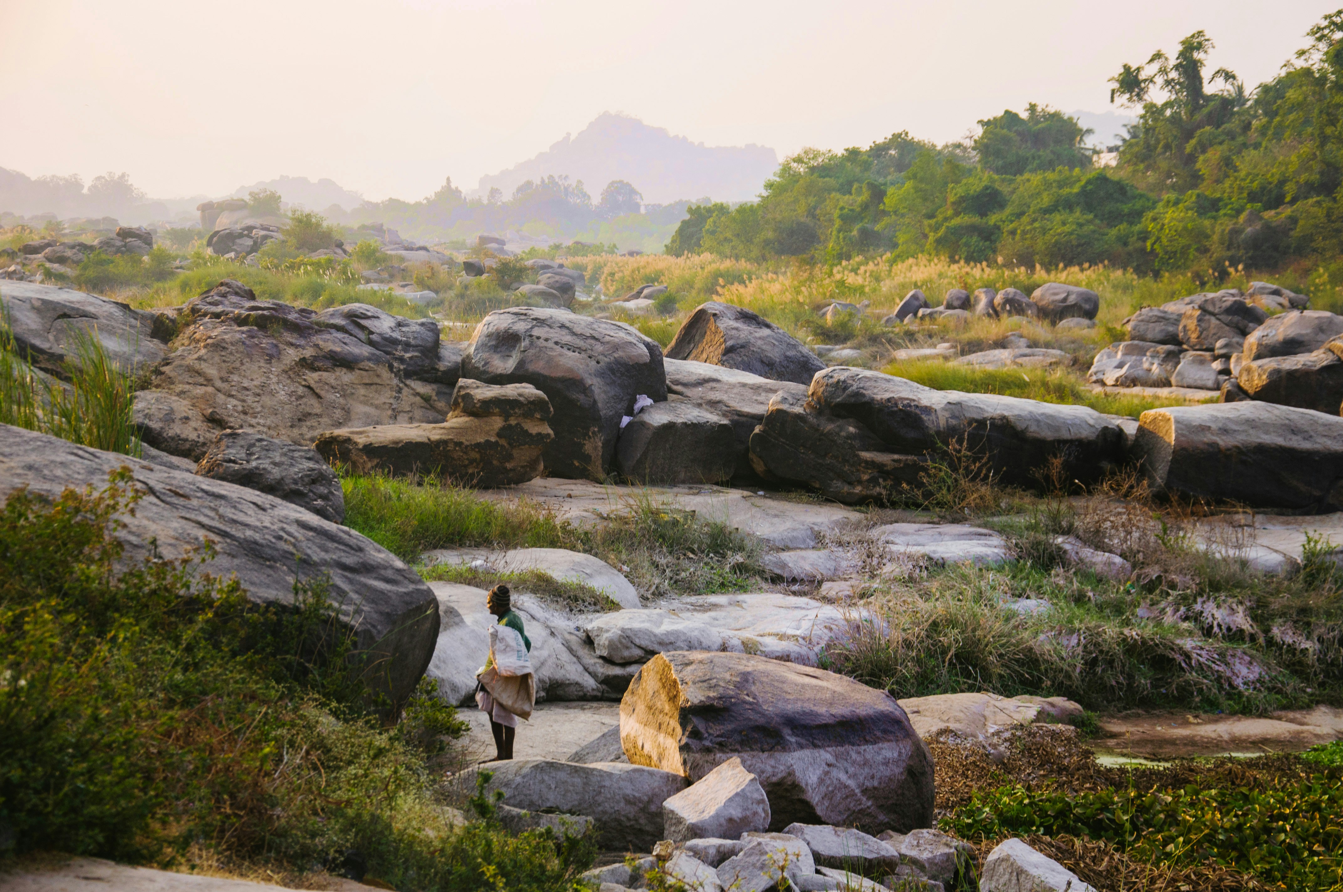 Lone Wanderer Across a Granite Riverbed at Dawn