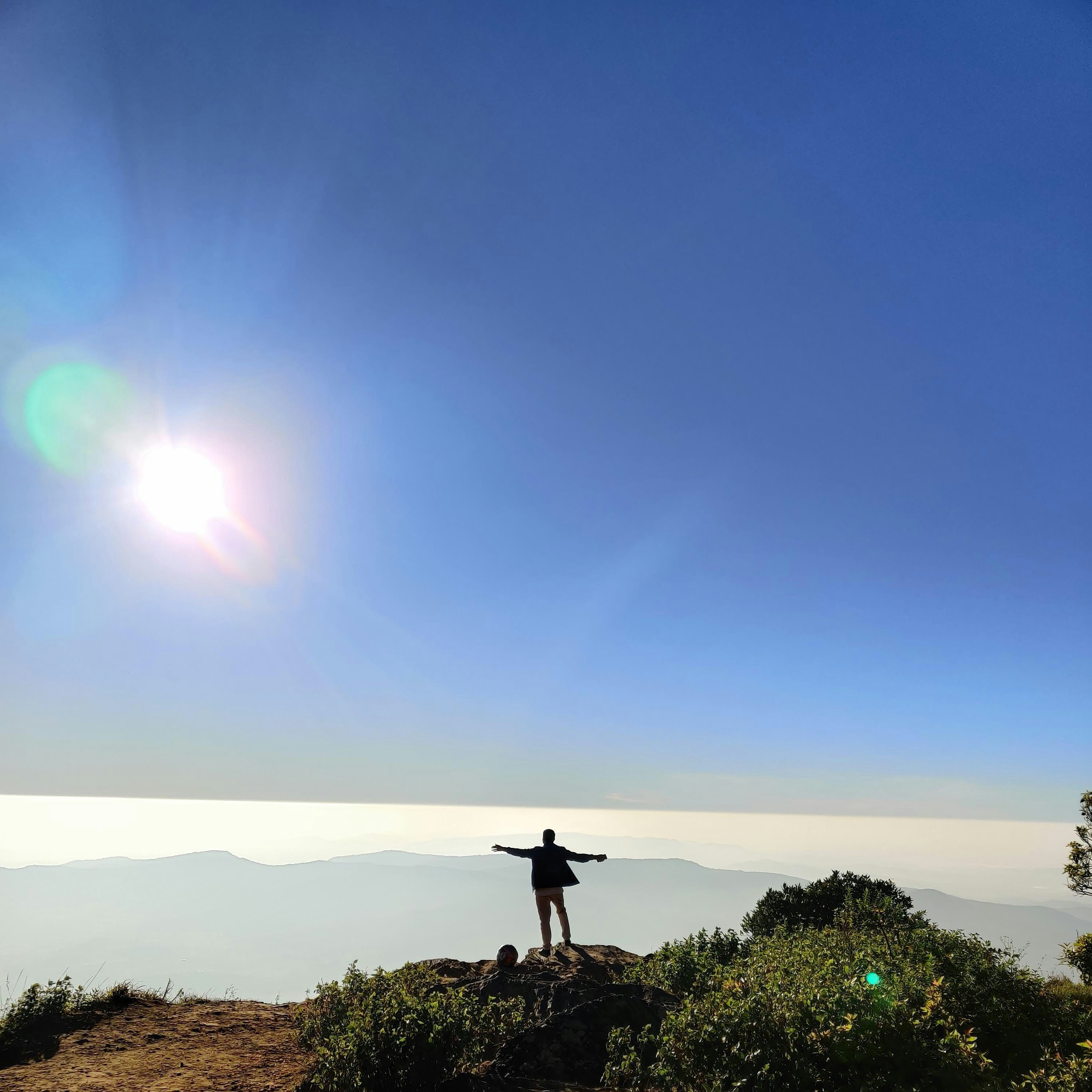 The breeze at 1895meters above sea level | person standing on rock near green grass during daytime