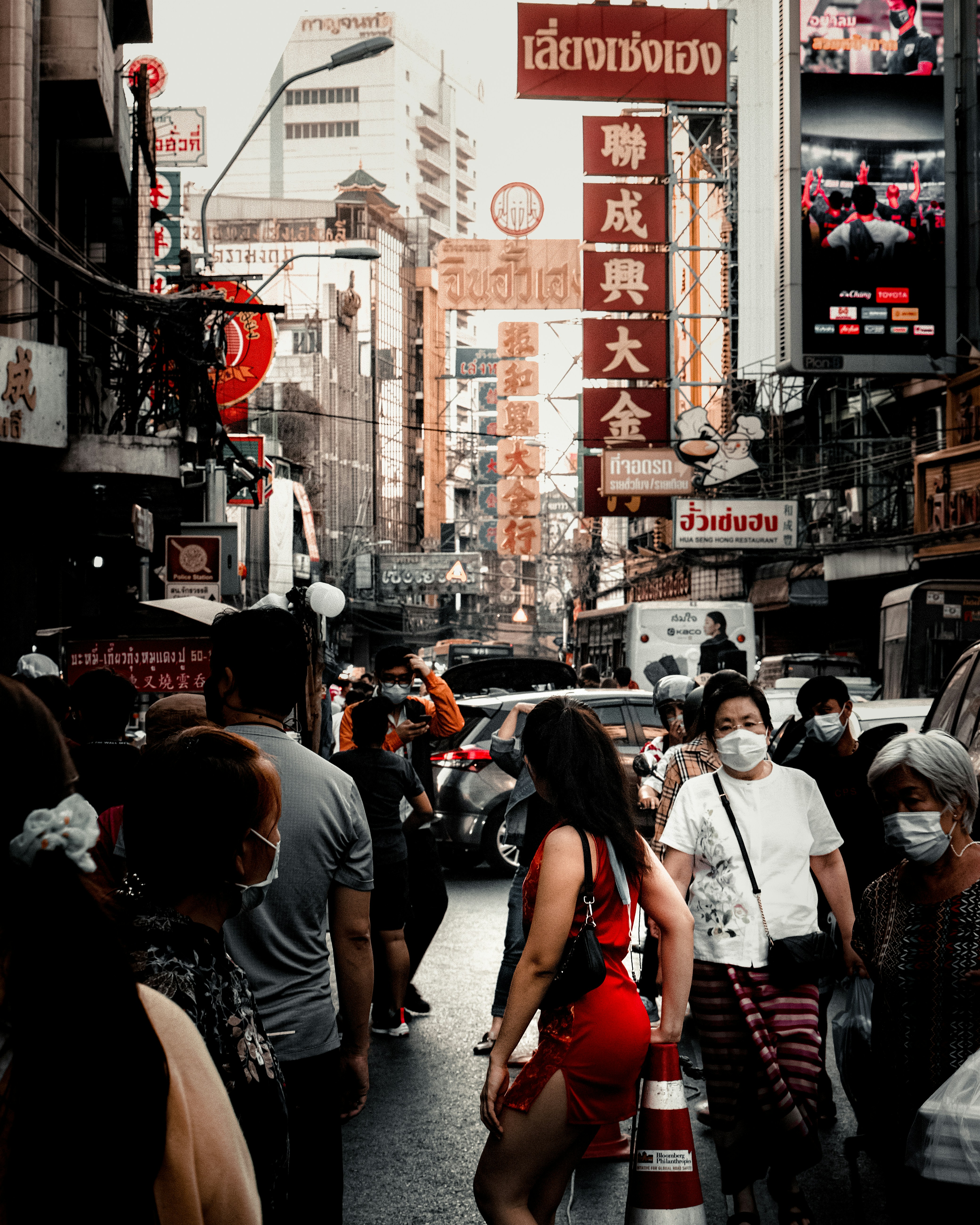 Red Dress Amid Neon Scrolls: A Crowded Street Scene in a Market District