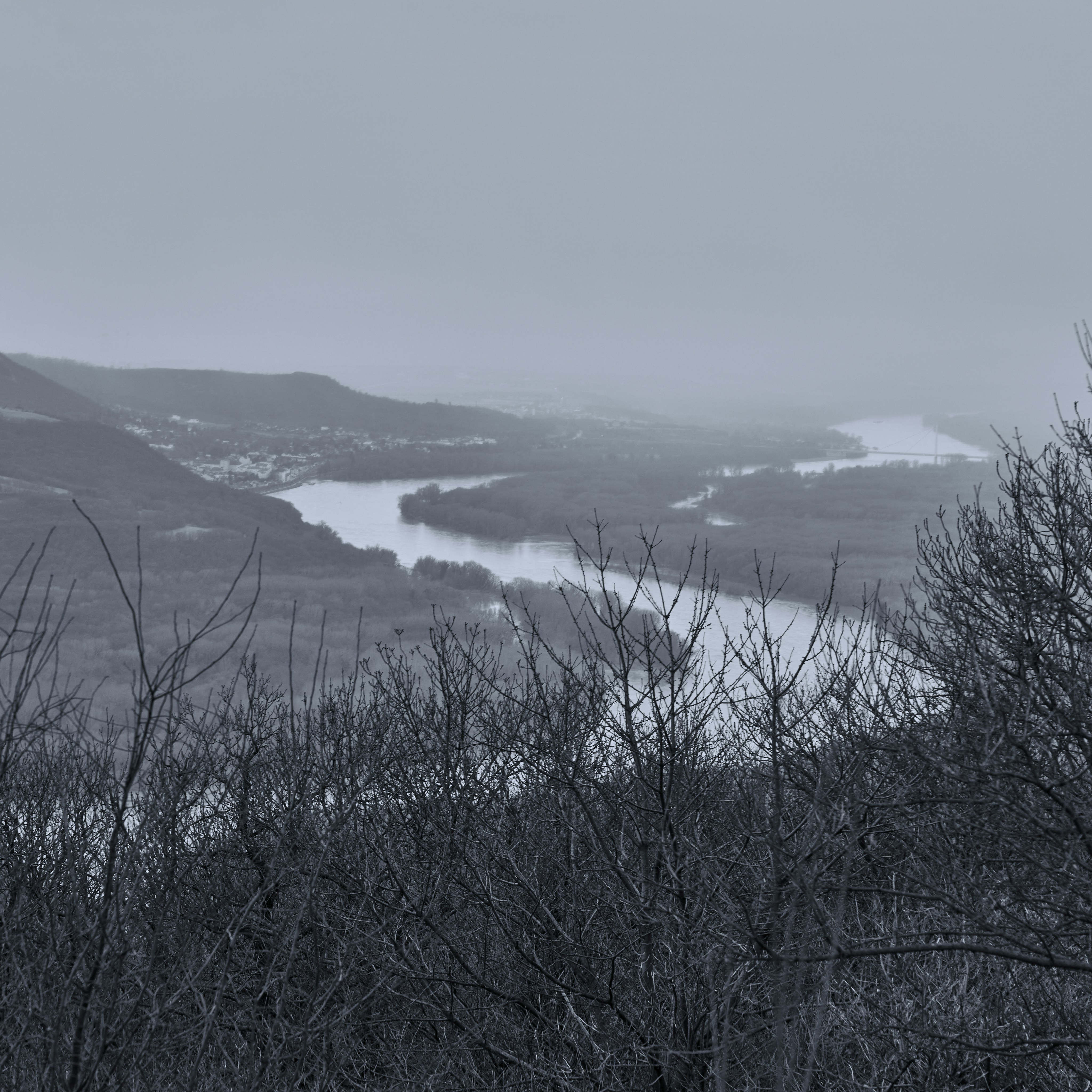 Snowbound River Valley Under Hazy Sky