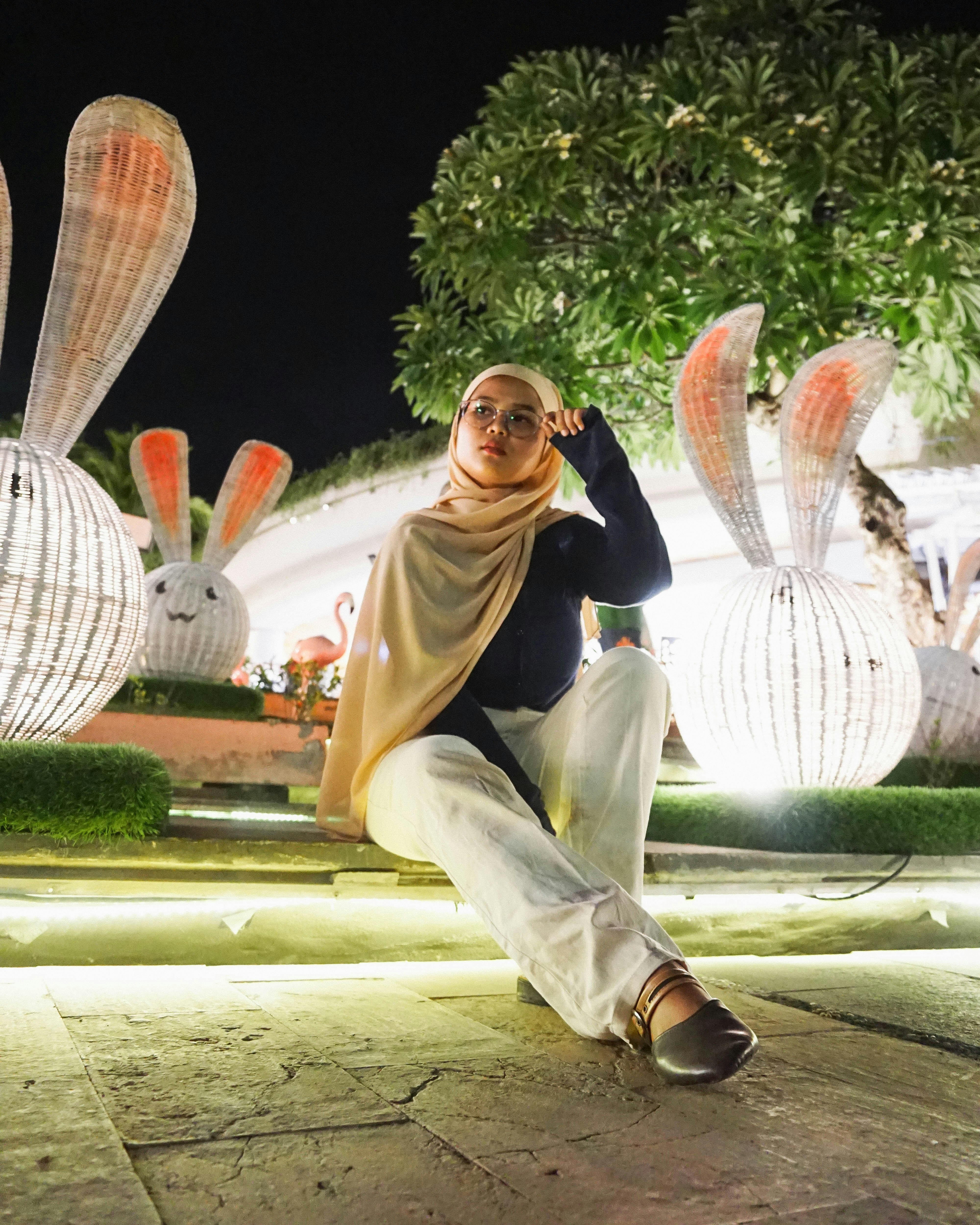Woman in brown hijab sitting on white concrete bench during daytime ...