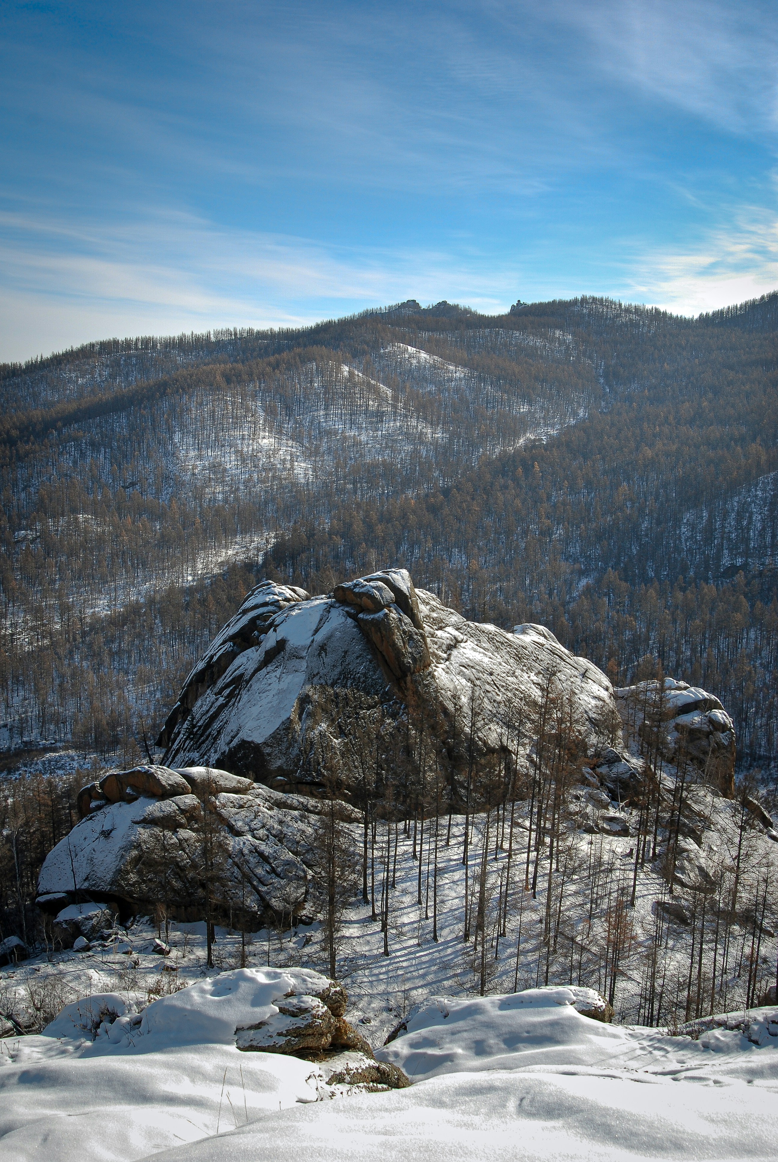 Granite Sentinel on a Snow-Kissed Ridge Under a Clear Winter Sky