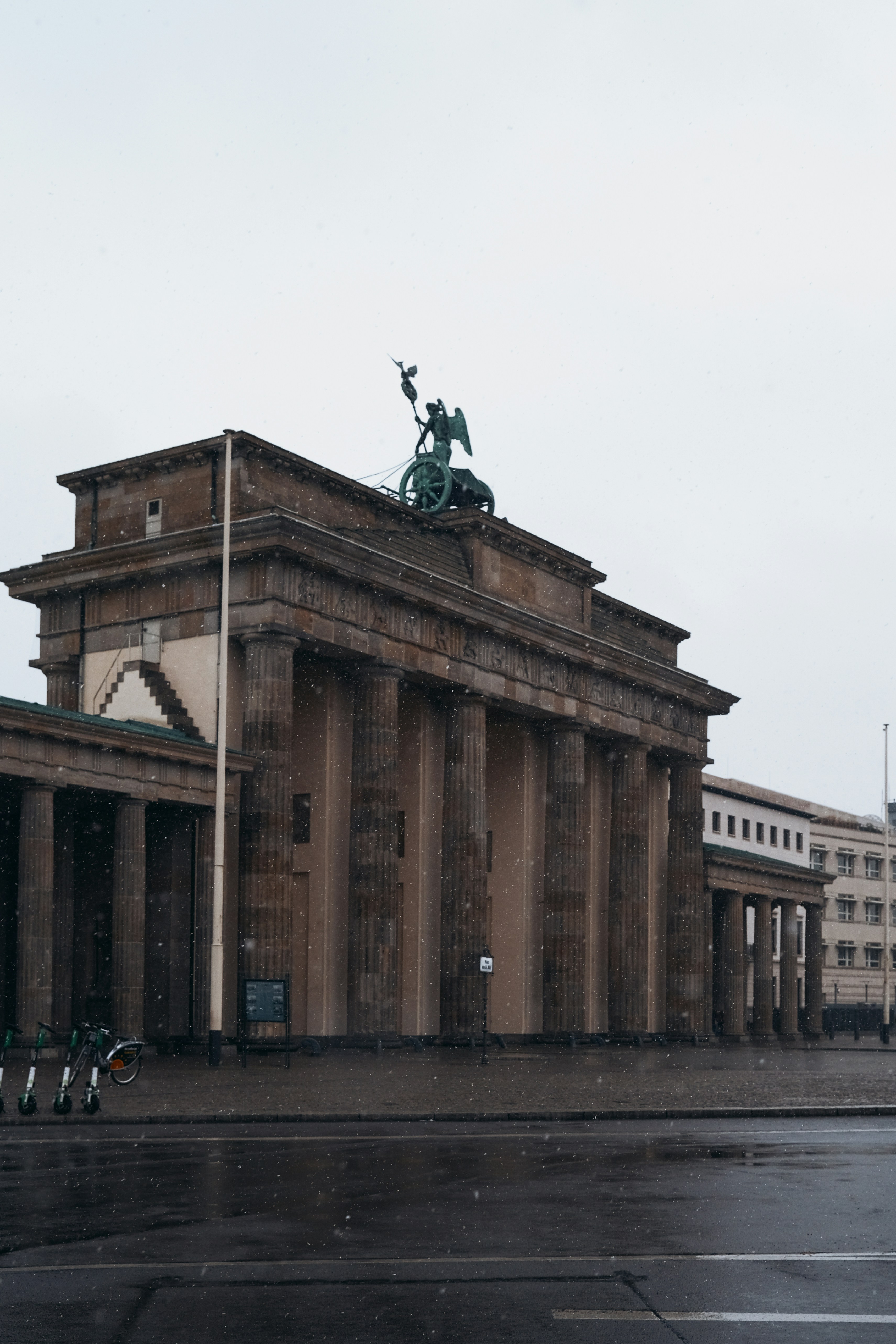 The Brandenburg gate in Berlin, Germany with snow falling in winter.