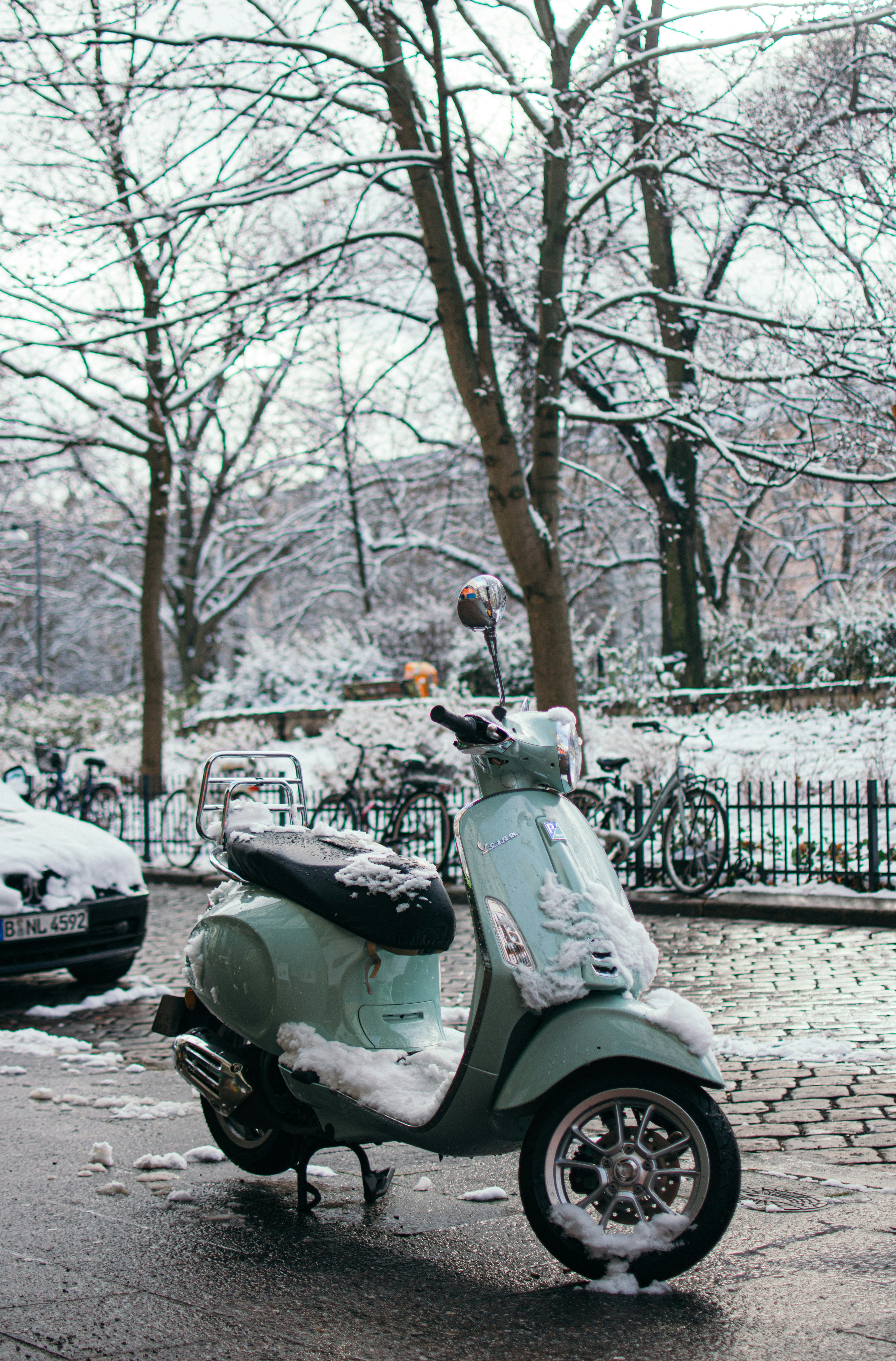 Black and white motor scooter parked on snow covered ground during ...