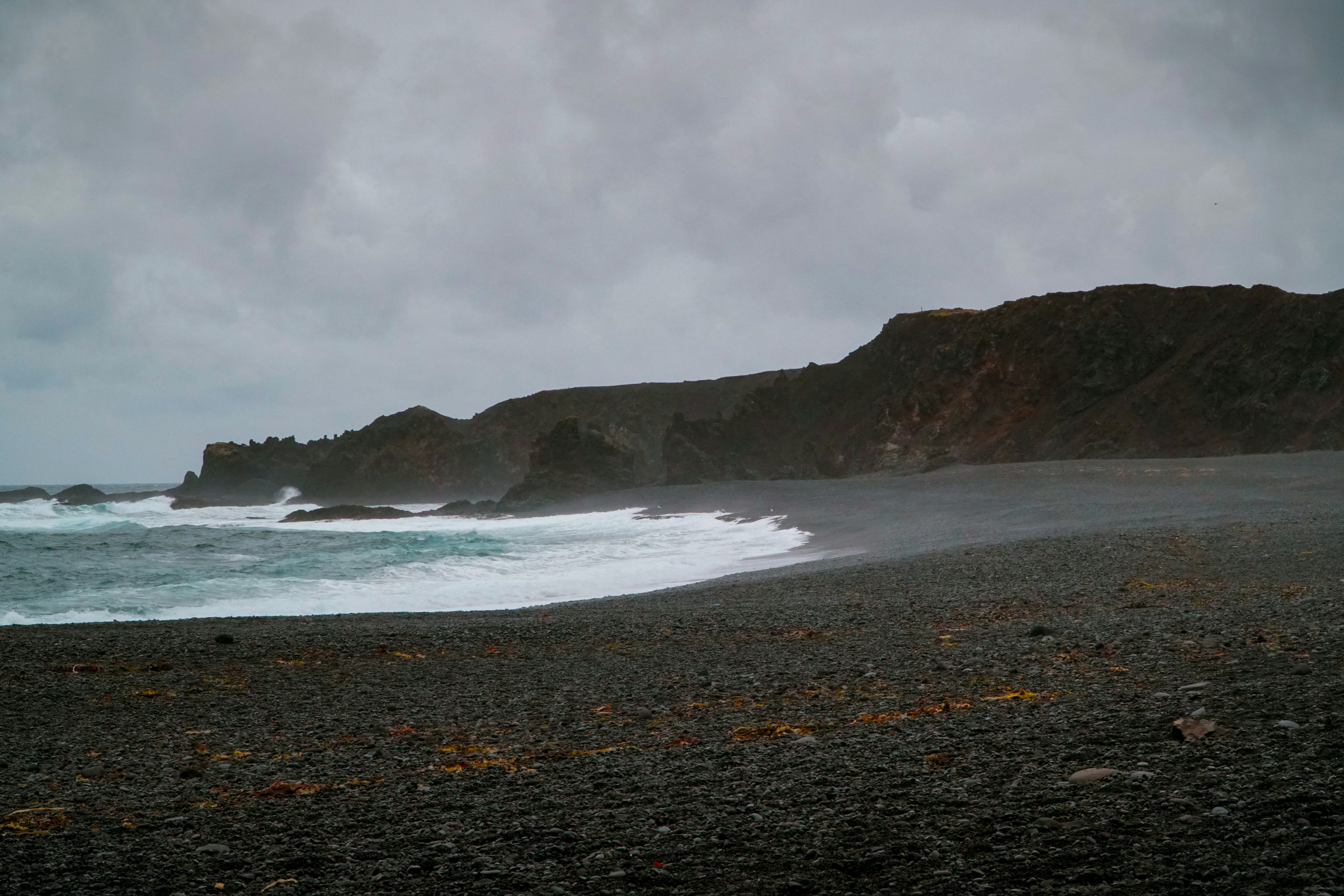 Storm-Gray Shore: Rugged Cliffs Guard a Pebble Beach