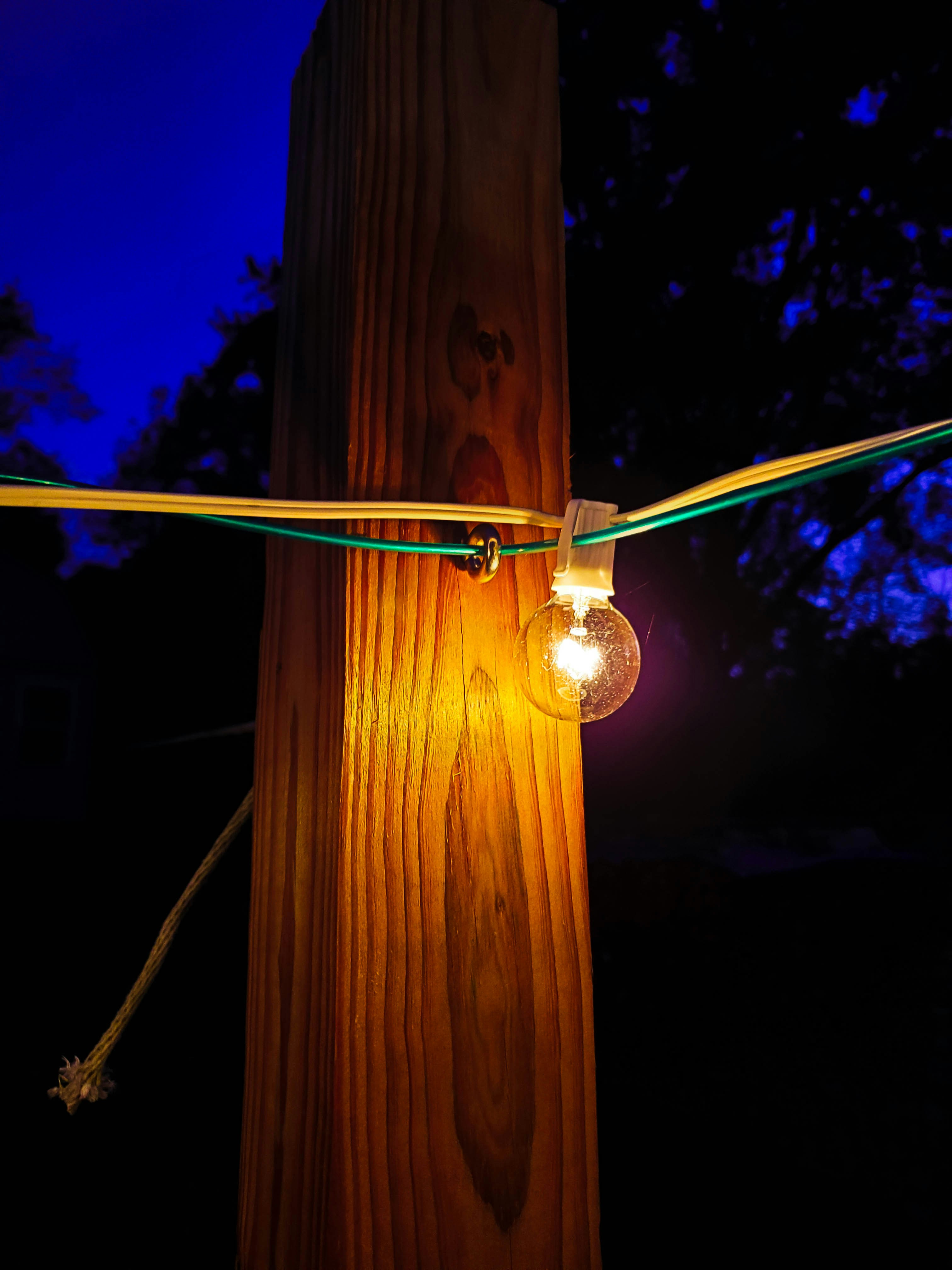 Amber Globe on a Timber Post: Night Glow with Colorful String Lights