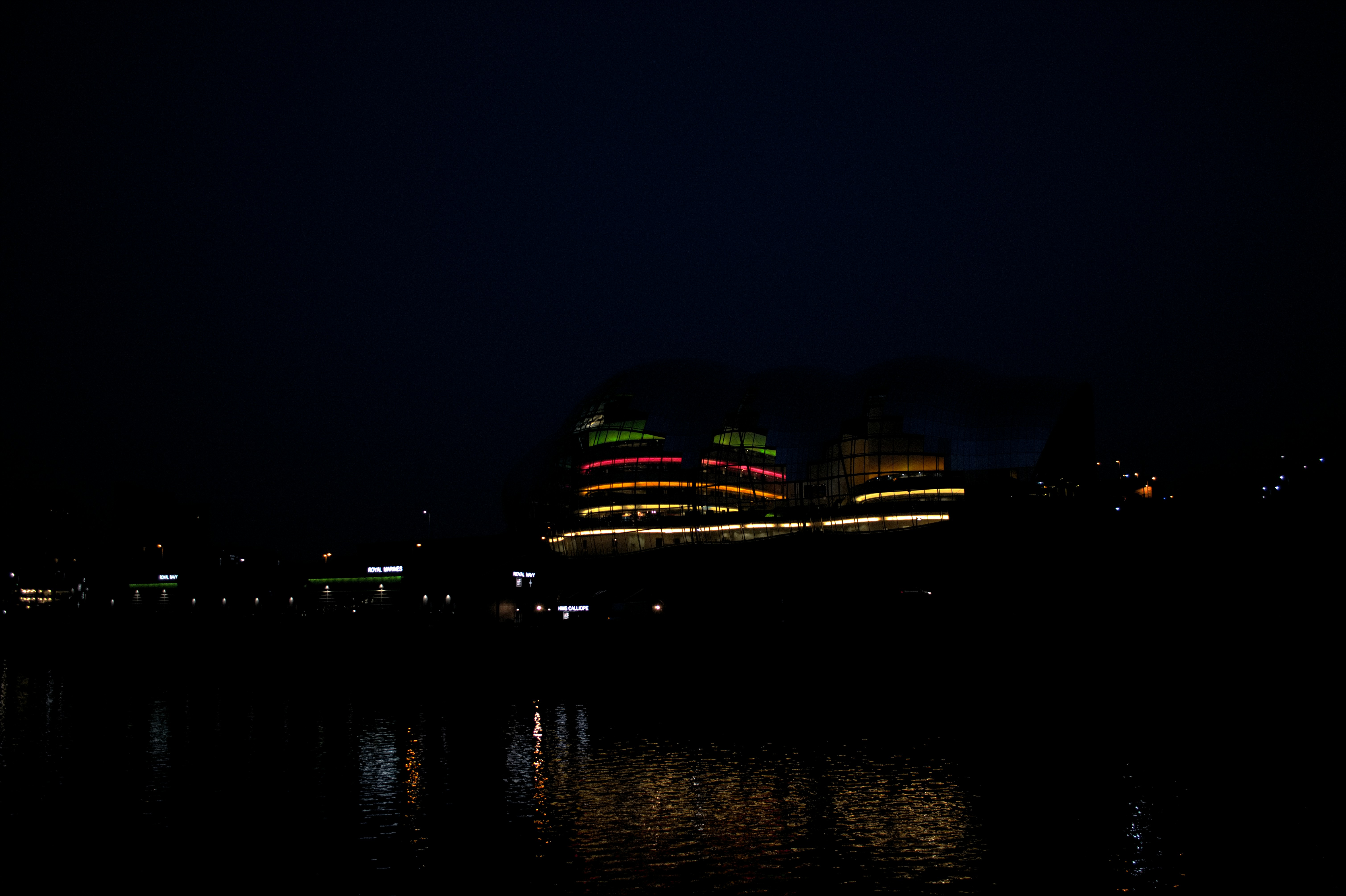 white and black building near body of water during night time