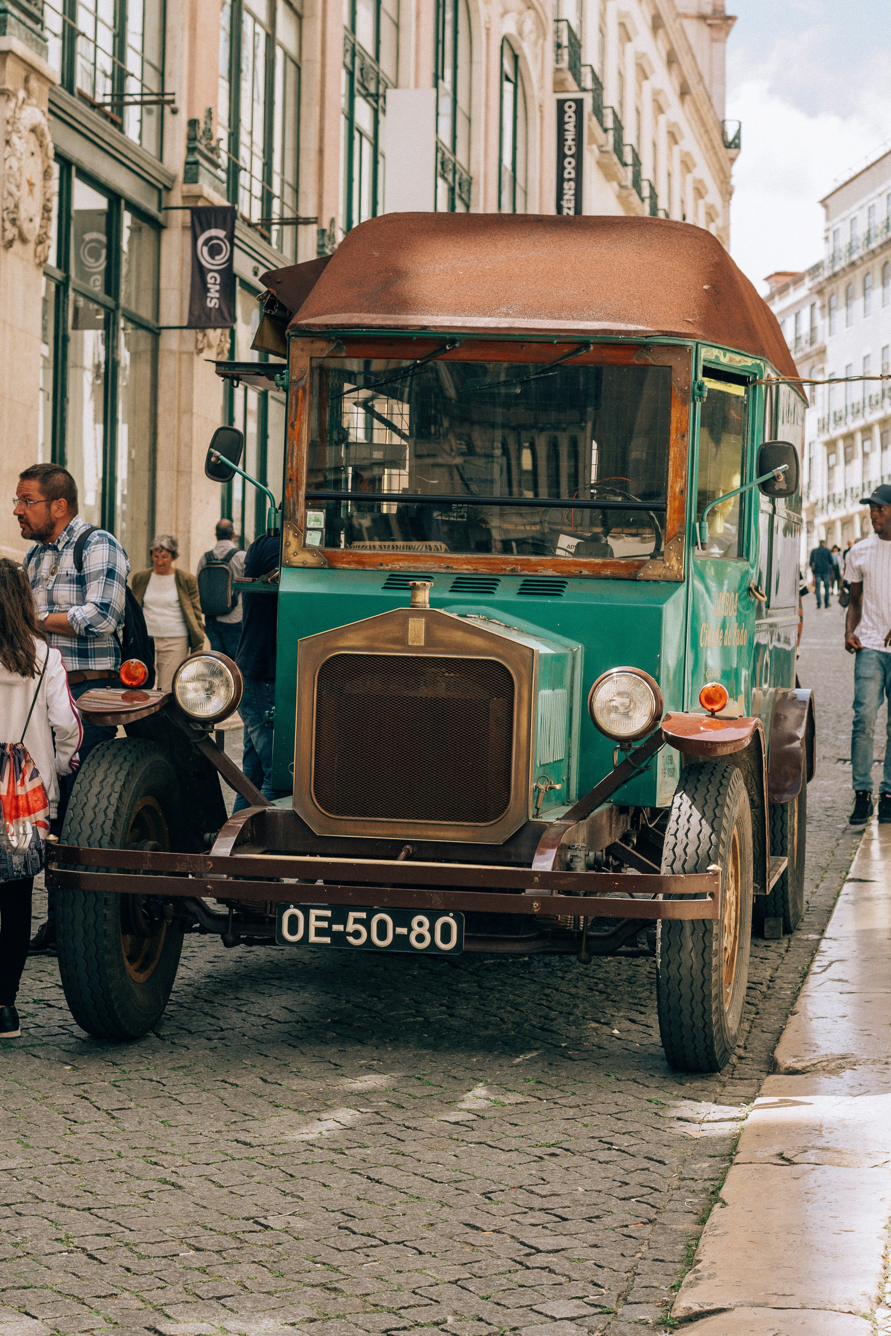 Turquoise Vintage Truck Anchors a Lively European Street