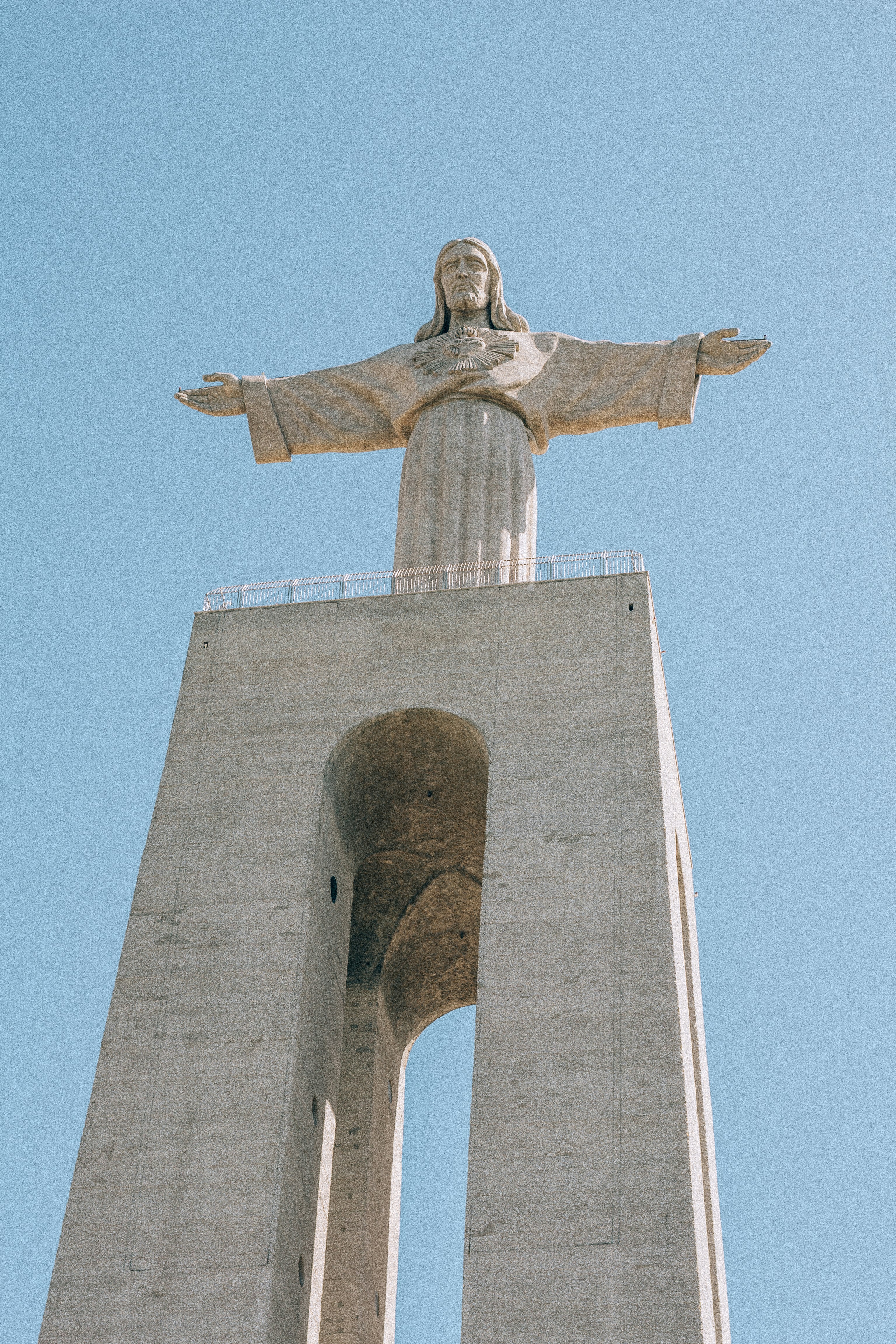 Open-Armed Colossus: Concrete Pillar Under a Clear Sky